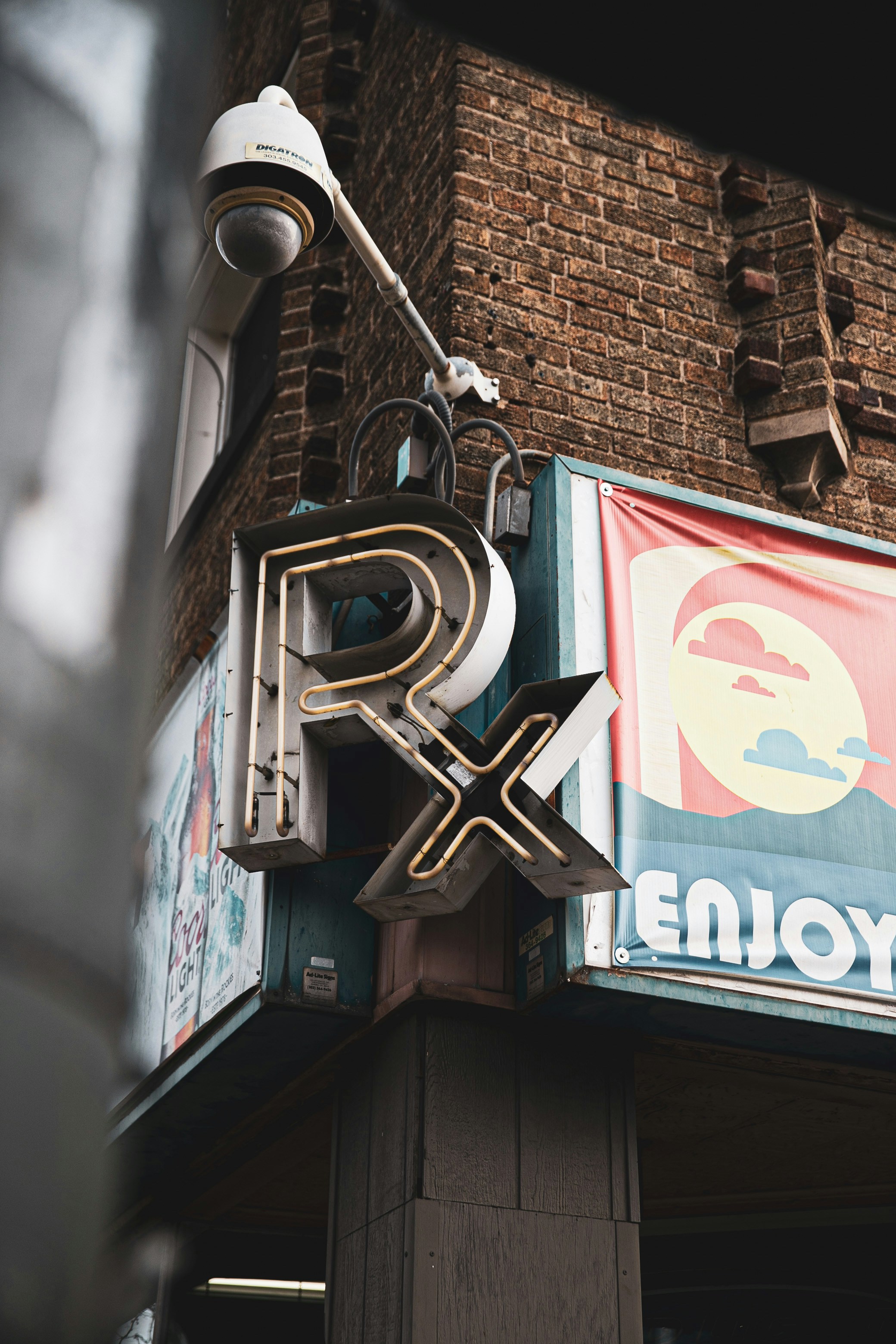 Neon Lettermark Over Brick: A Street Signcarved in Time