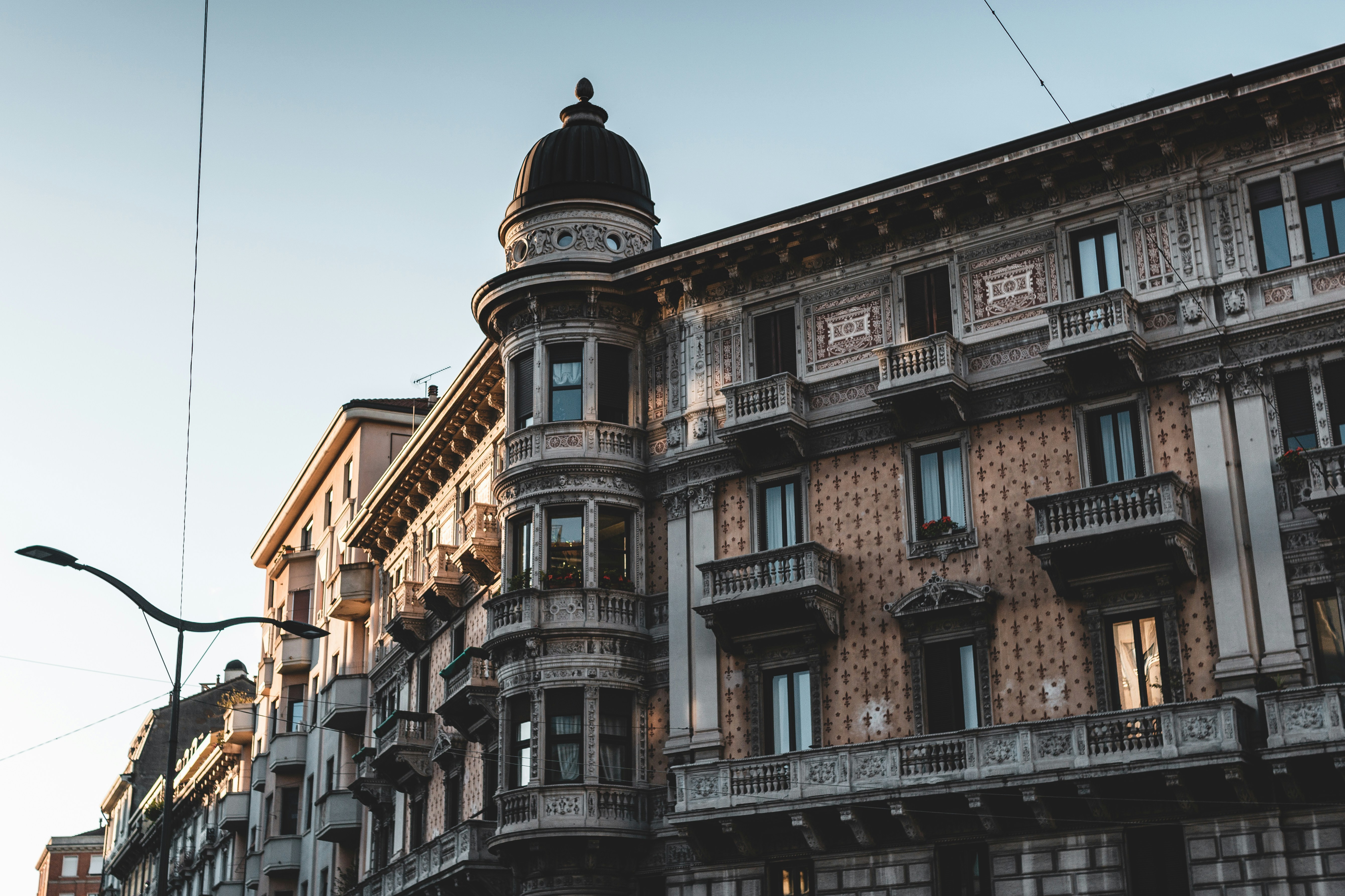Historic building with ornate facades and balconies, illuminated by the soft glow of evening light.