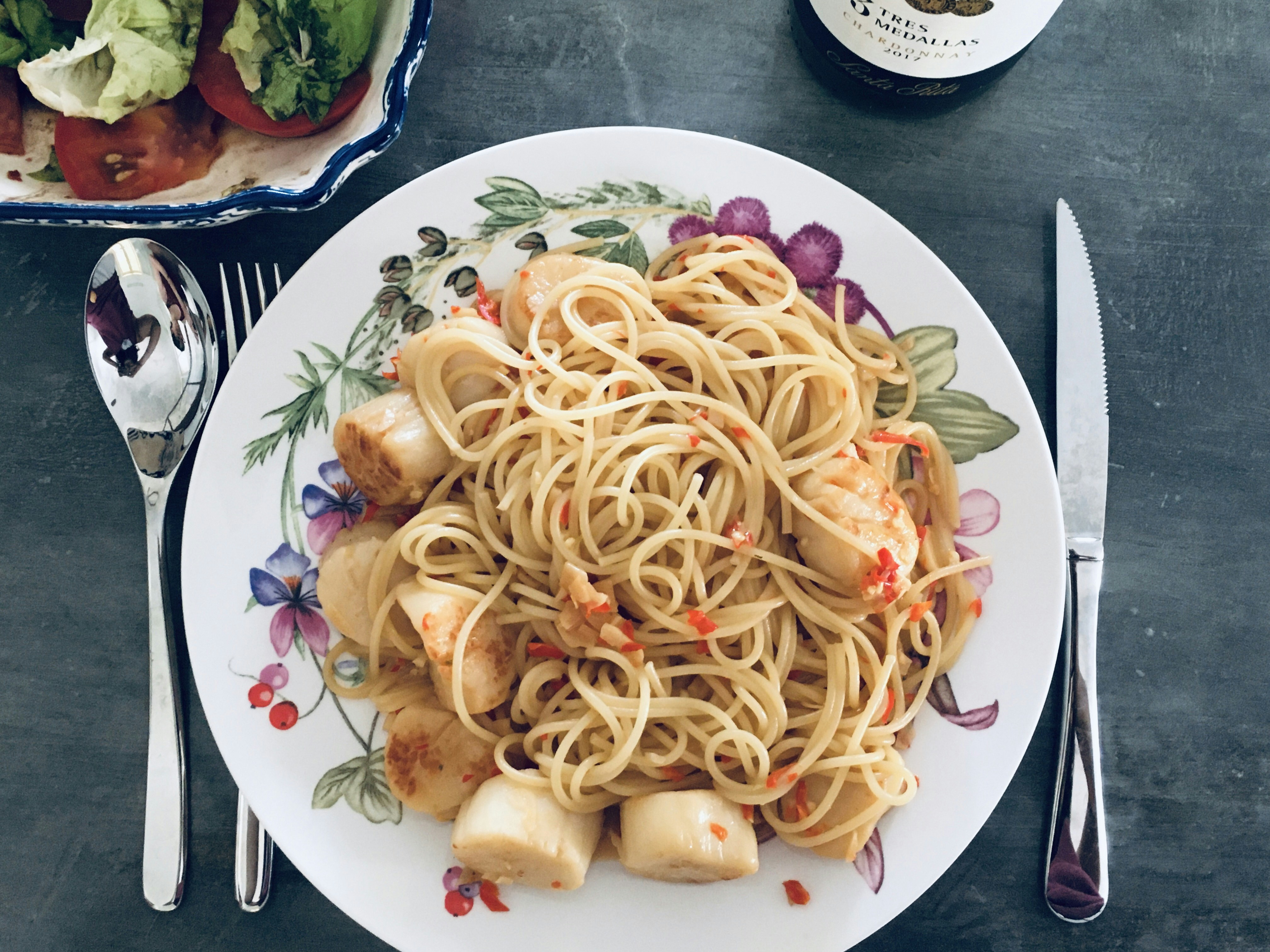 Spaghetti with sliced banana on plate with spoon, fork, and knife photo ...