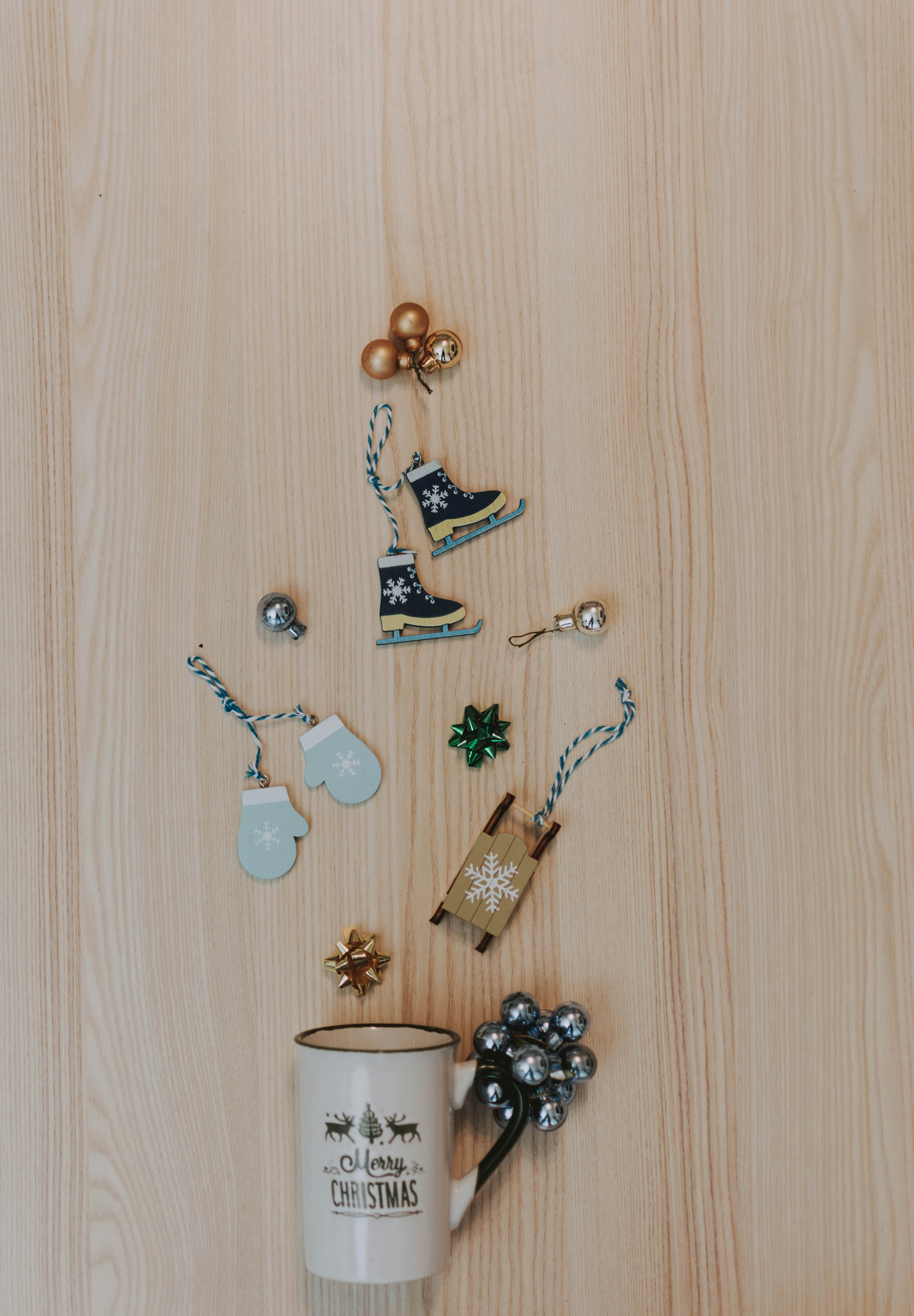 A festive display featuring miniature ice skates, mittens, and a decorative mug, all set against a warm wooden backdrop.