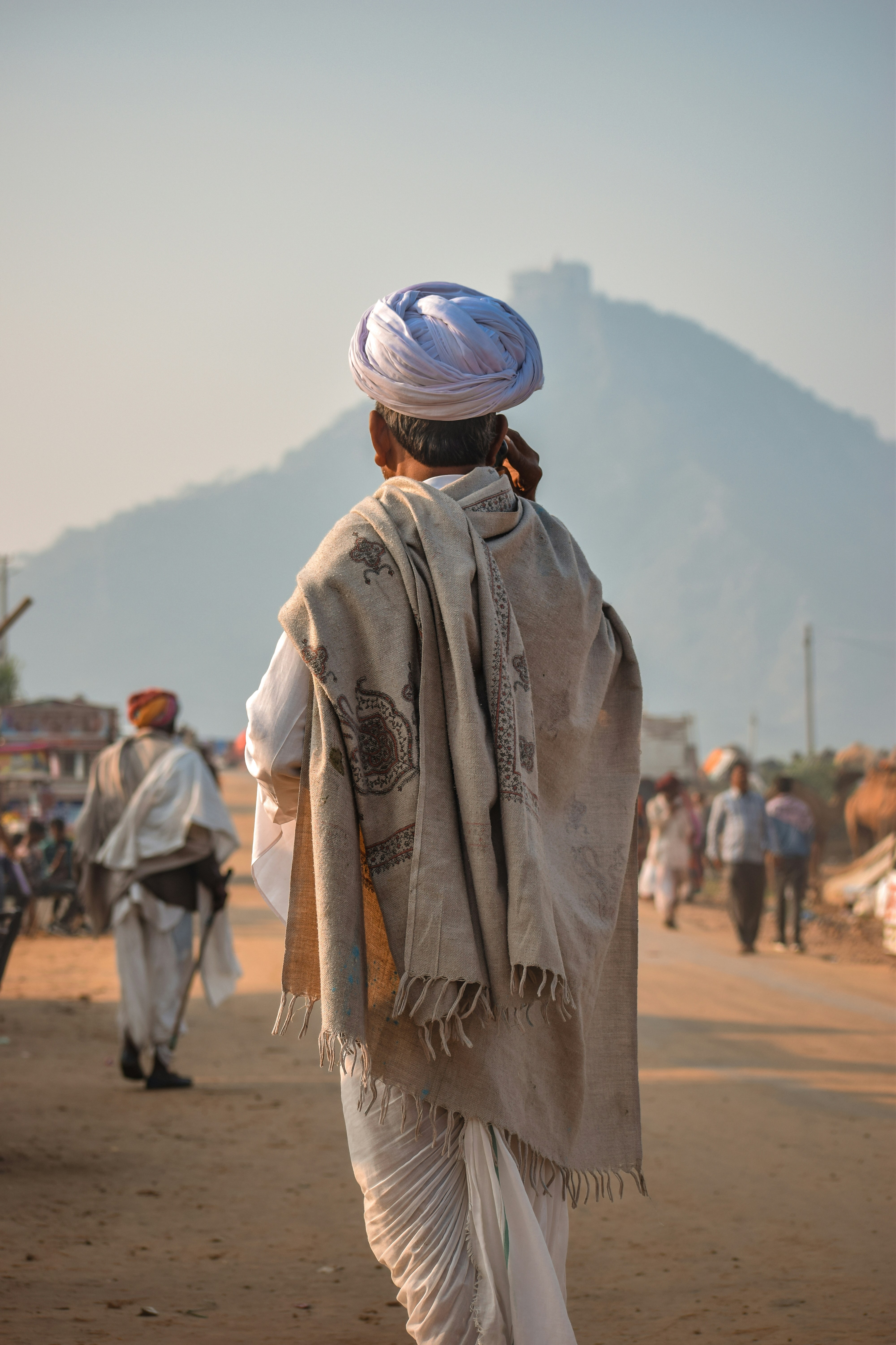 Turbaned Traveler in a Dusty Street, Framed by a Hill Fort at Dusk