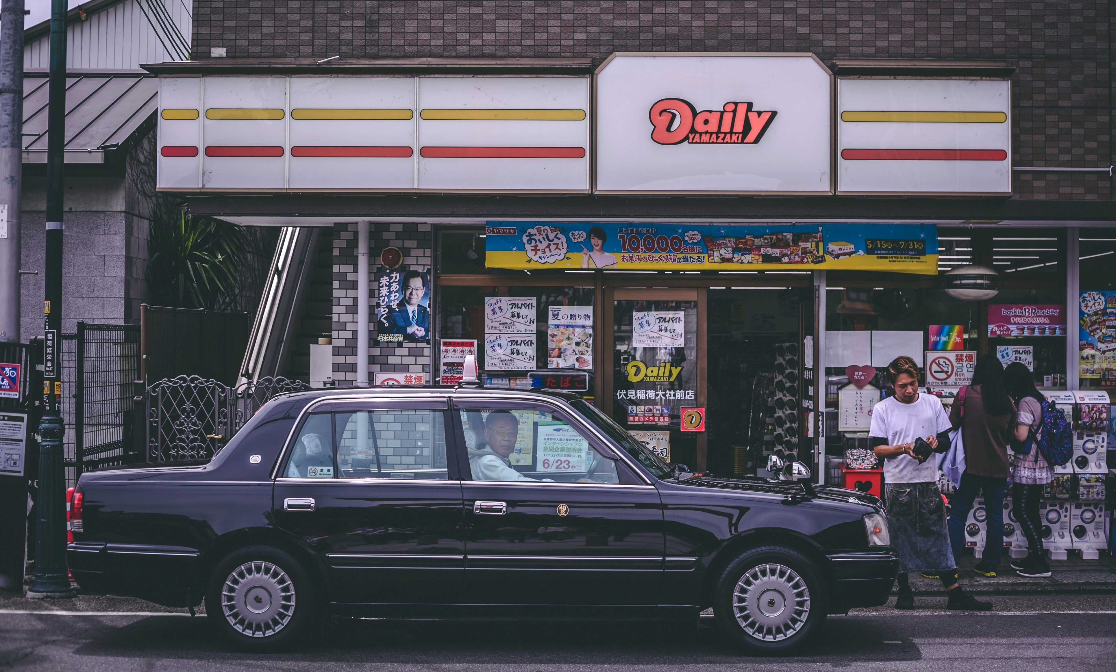 Midnight Black Taxi Pauses Outside a Neon-Trimmed Daily Store