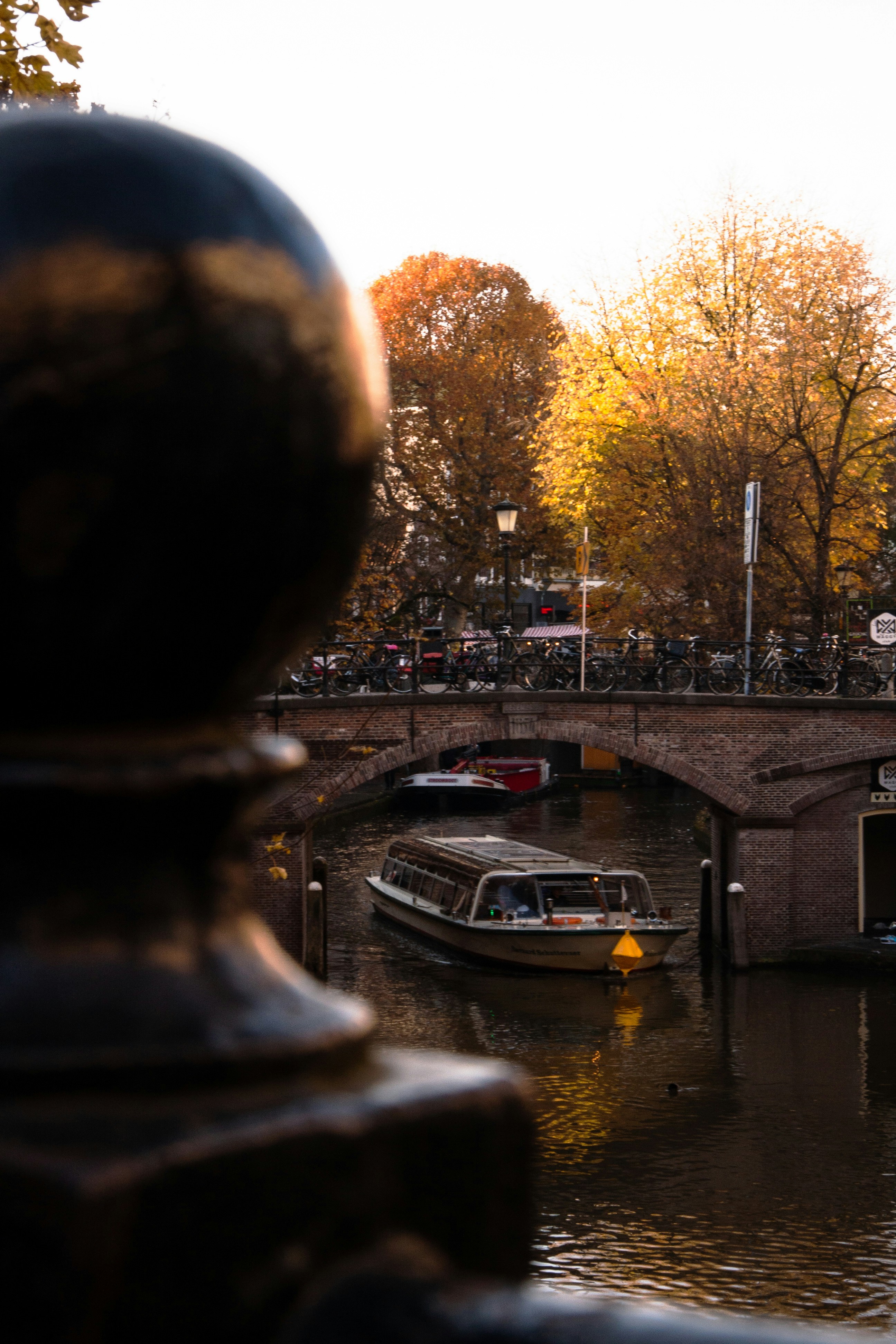 Bridgeboat at Dusk: A Quiet Canal Scene Framed by Autumn Light