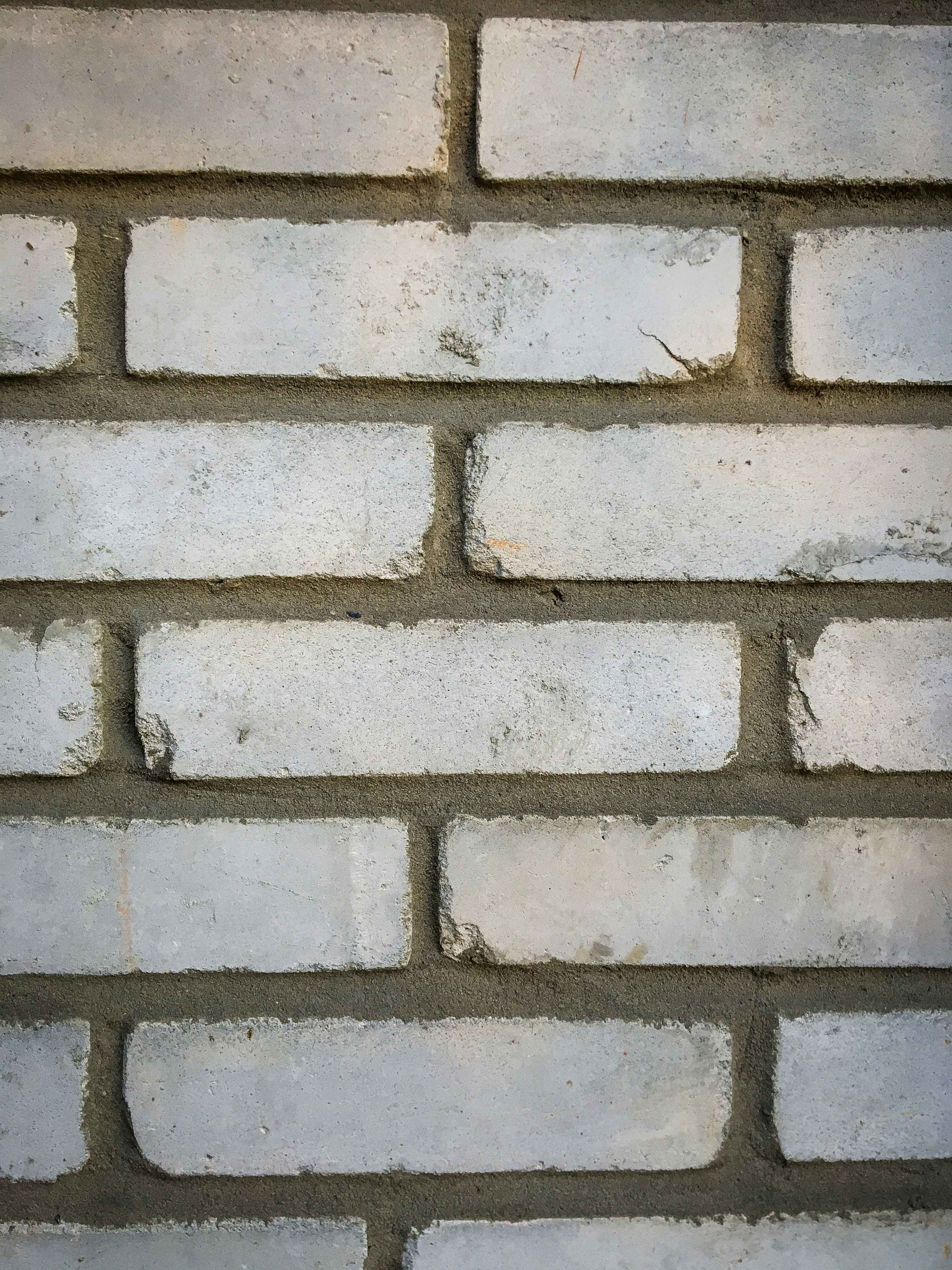 Close-up view of a textured brick wall, showcasing the subtle variations in color and surface detail. The arrangement highlights the craftsmanship of masonry.