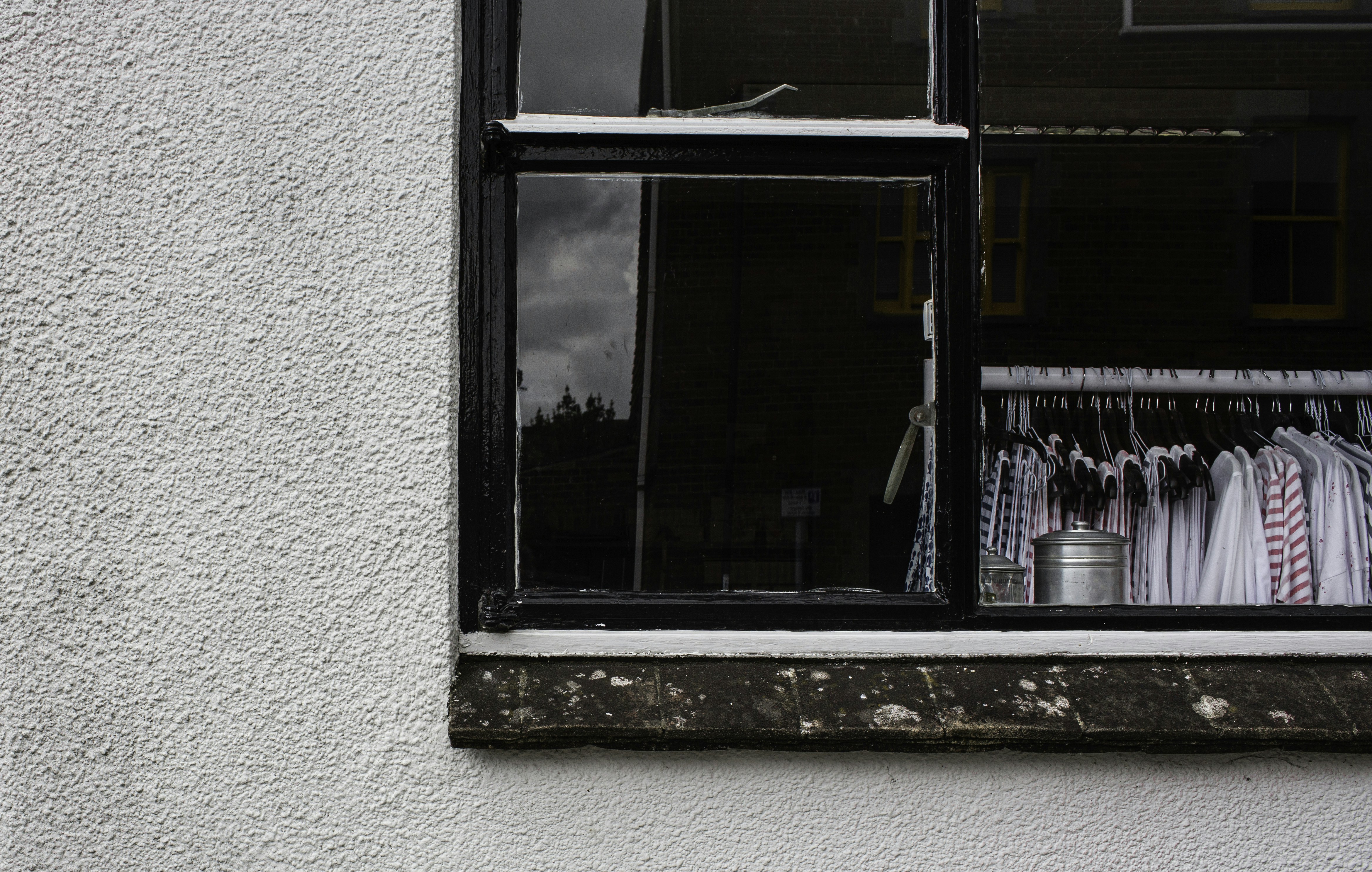 a window that has some clothes hanging on a rack