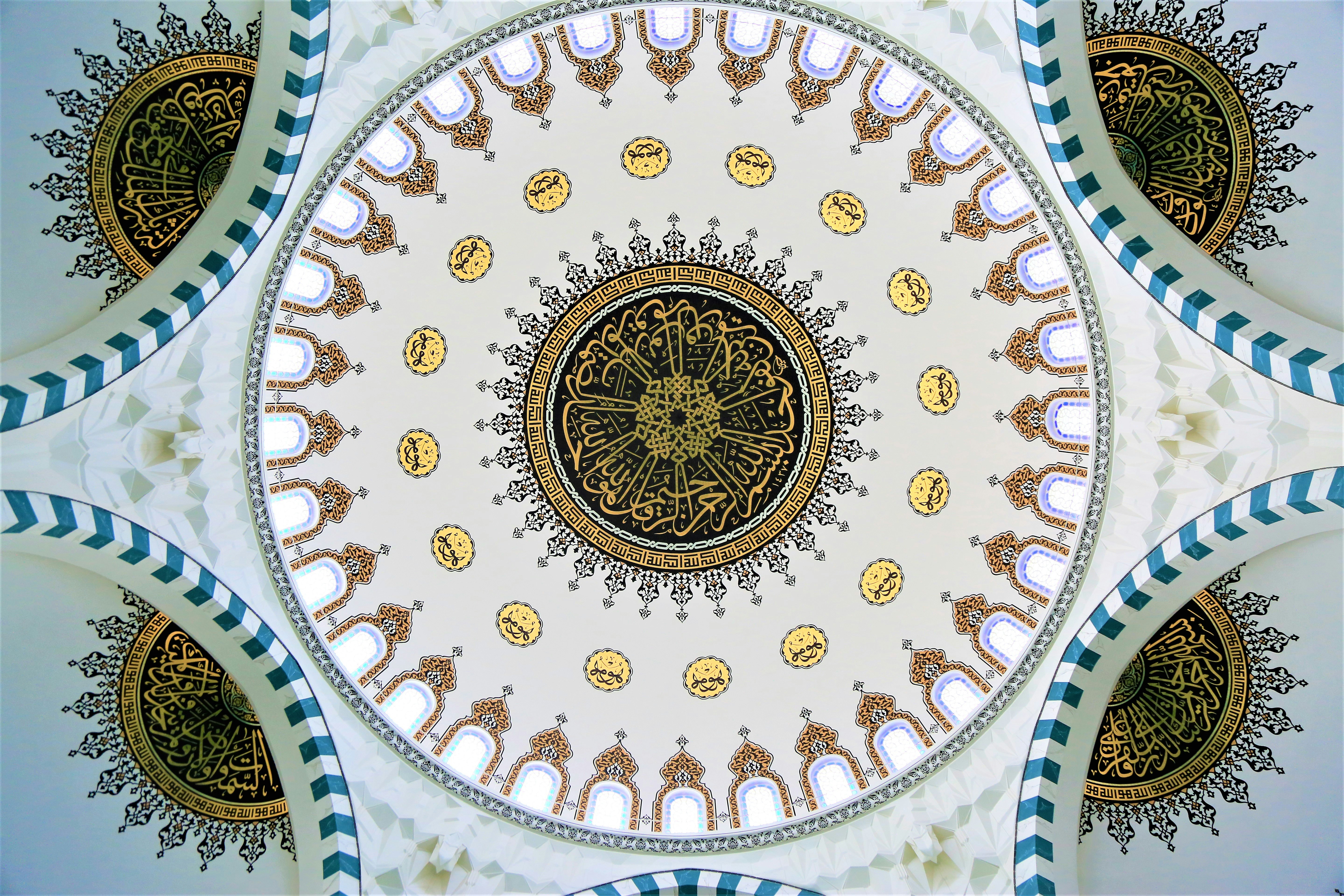 Intricate ceiling design featuring ornate patterns and golden inscriptions in a grand architectural space.
