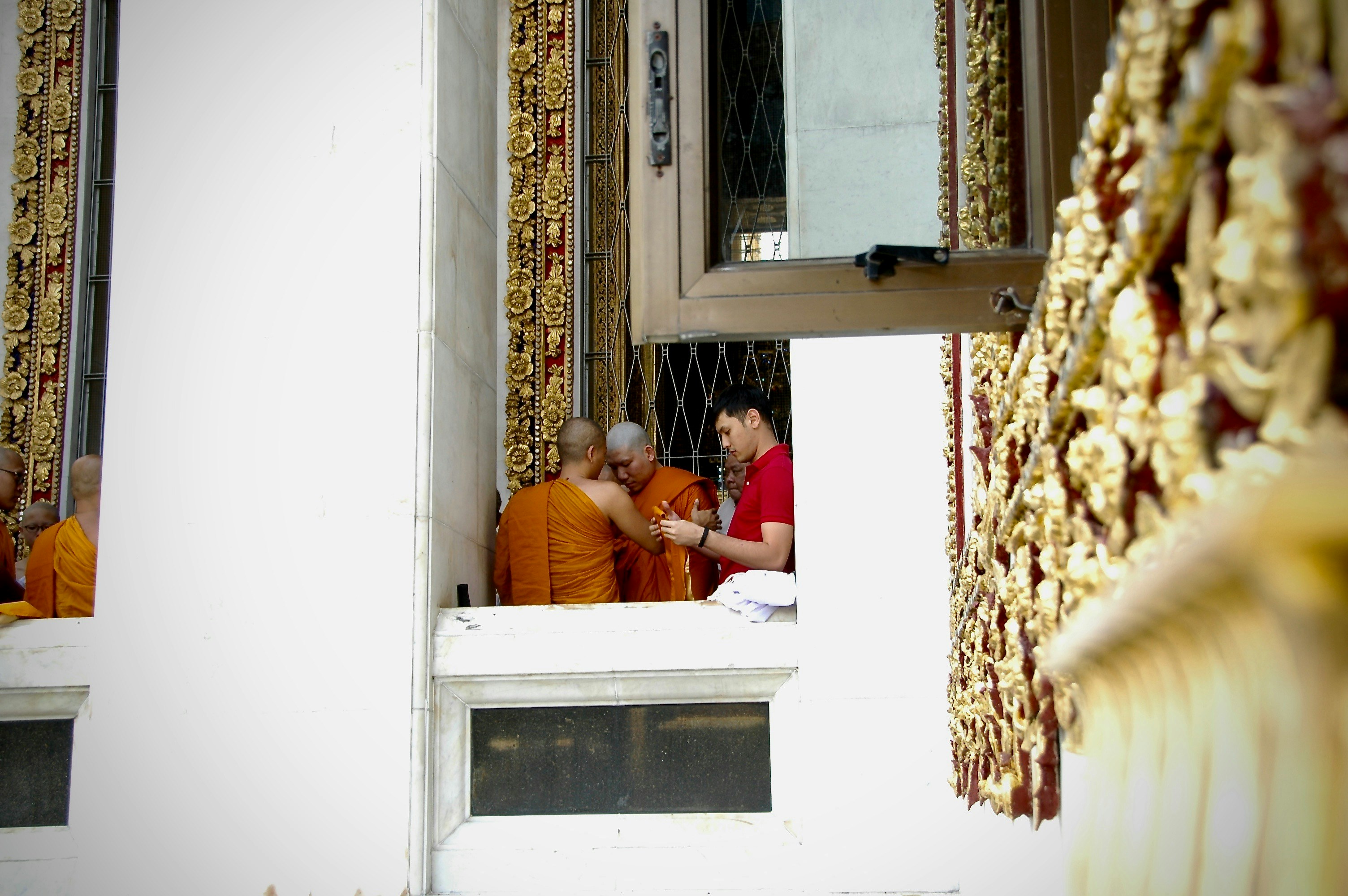 Whispered Exchange on a Sunlit Temple Balcony