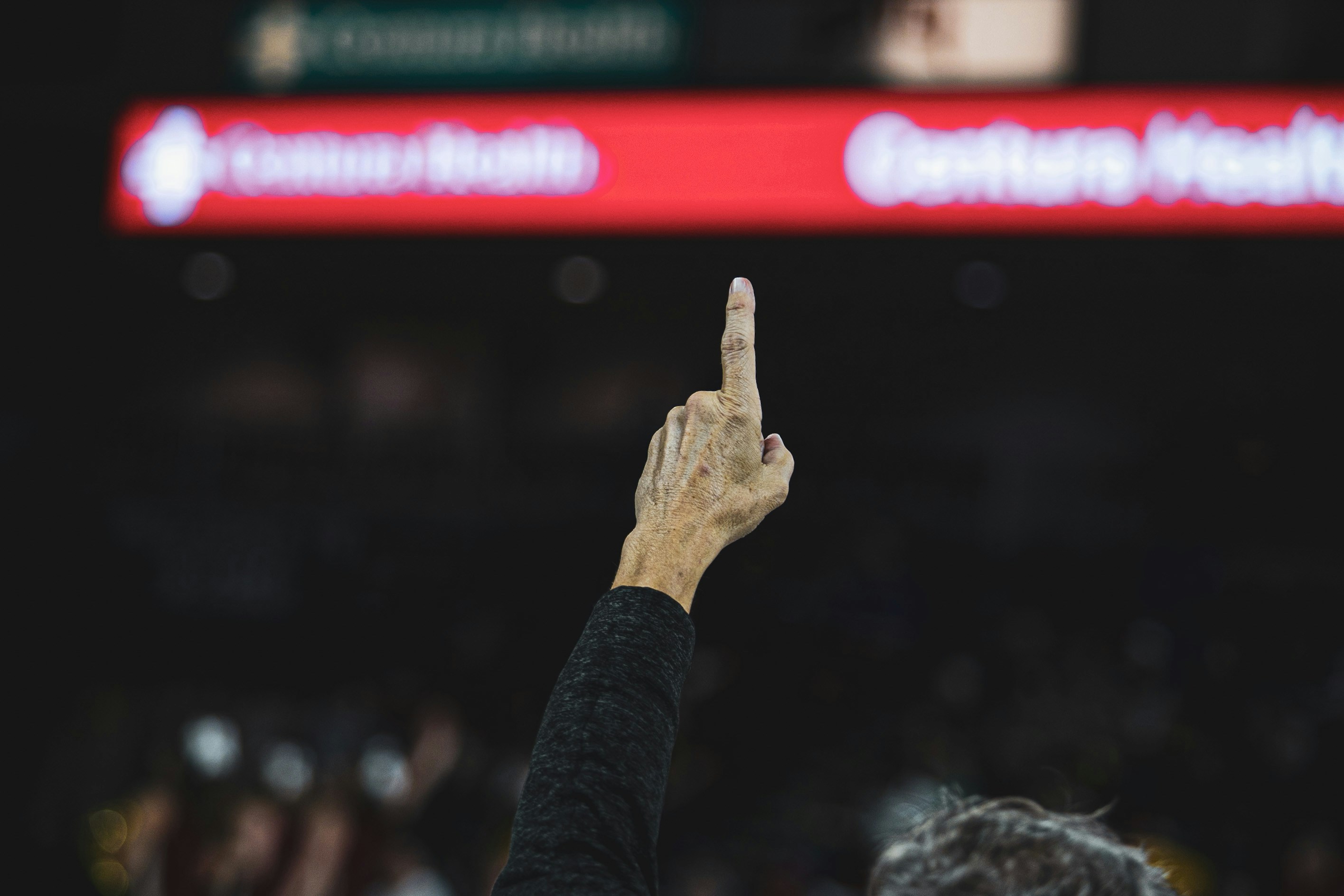Raised Finger Under Stadium Glow: A Rallying Gesture in the Crowd