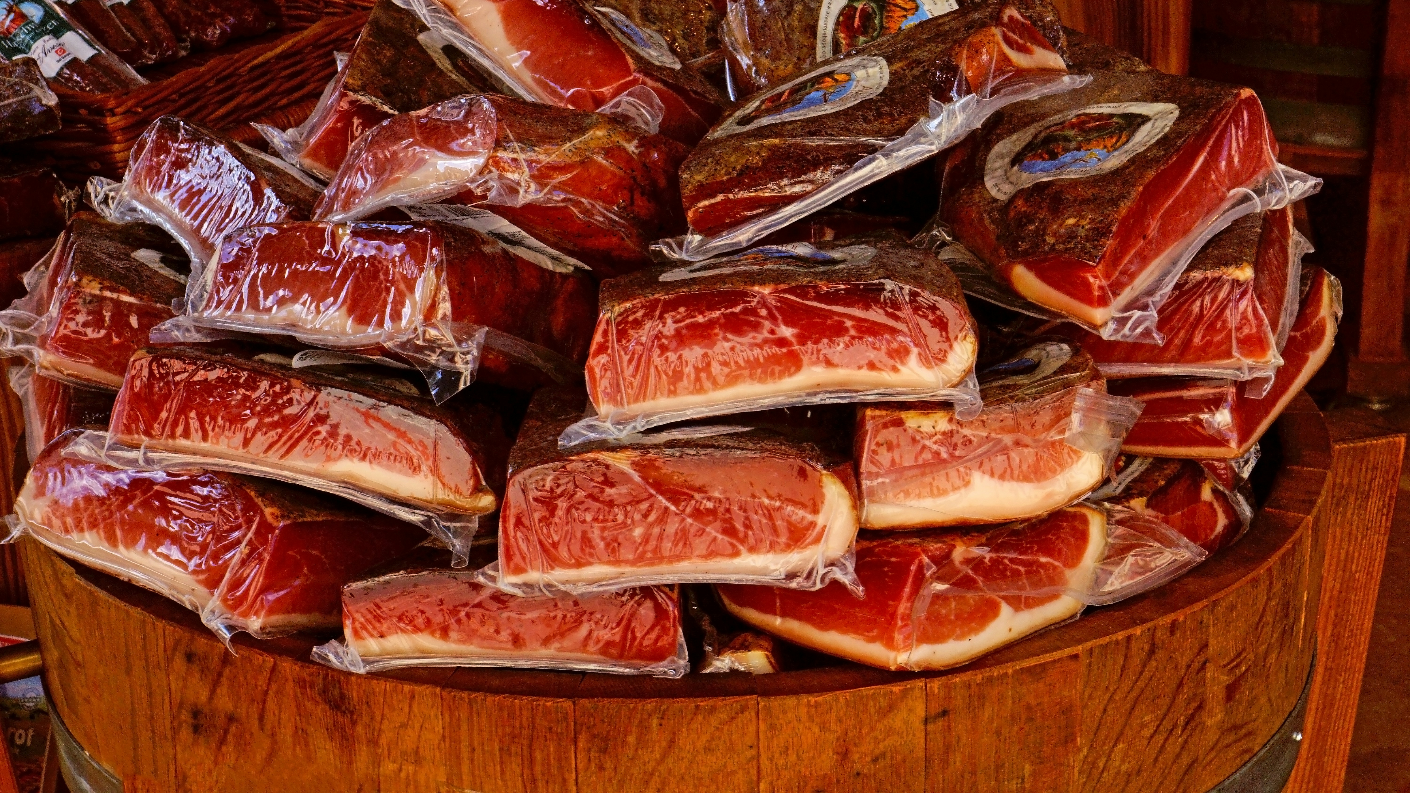Stacked Marbled Beef on a Wooden Barrel Beneath Warm Market Light