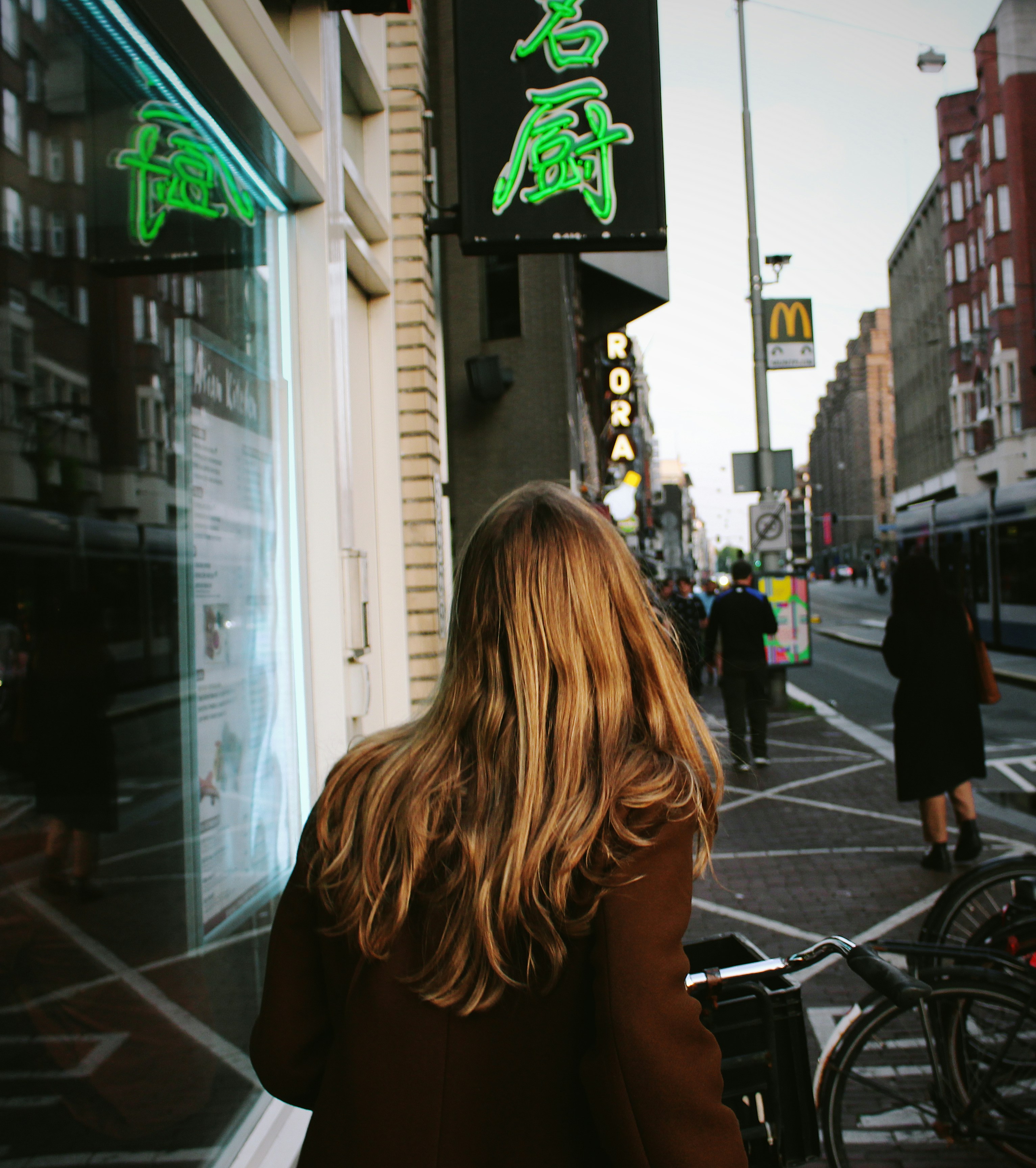Over-the-Shoulder Walk: A Blonde Globe in a City Pulse