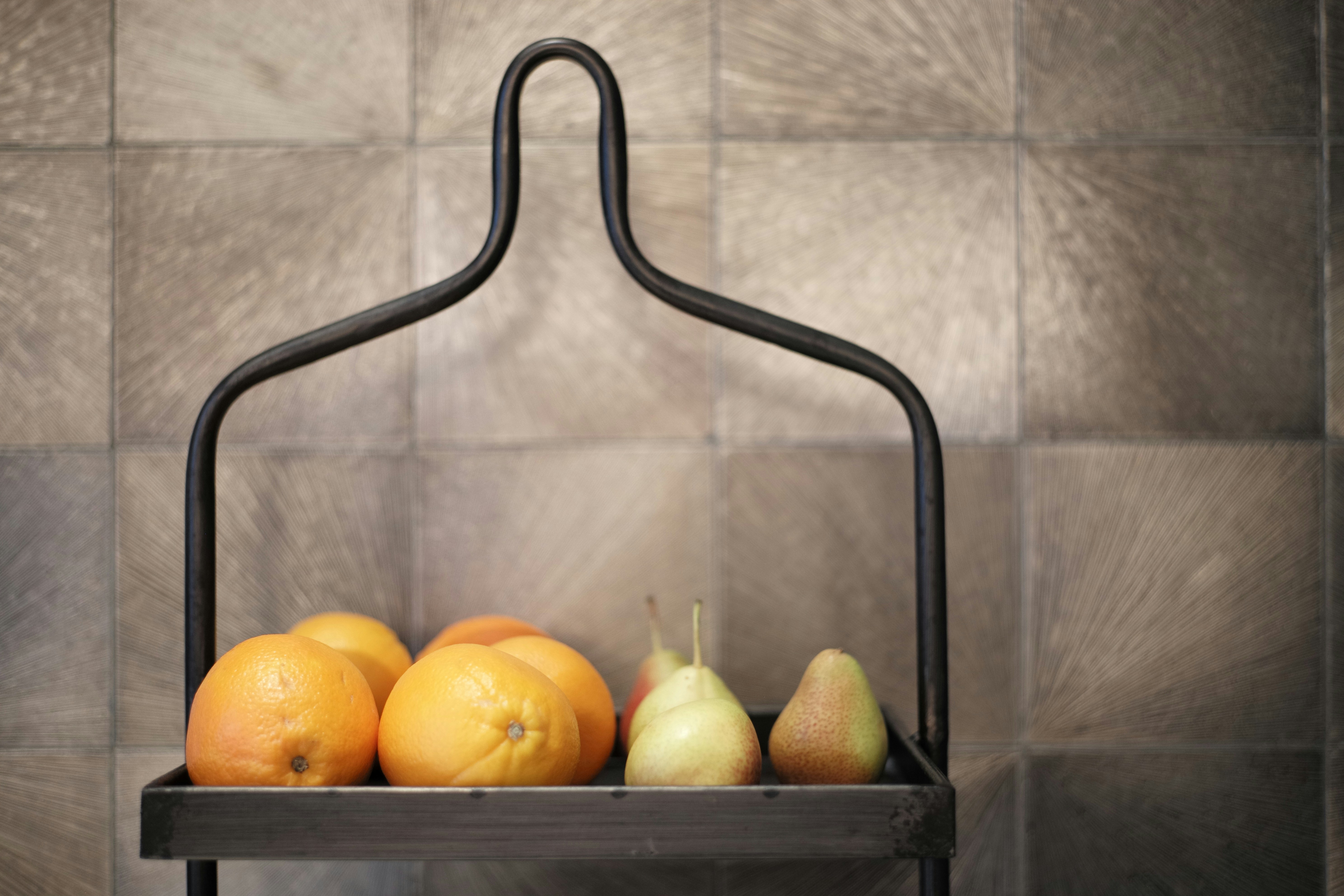 Tiled Backdrop, Golden Bite: A Minimal Still-Life of Oranges and Pears on a Rimmed Tray