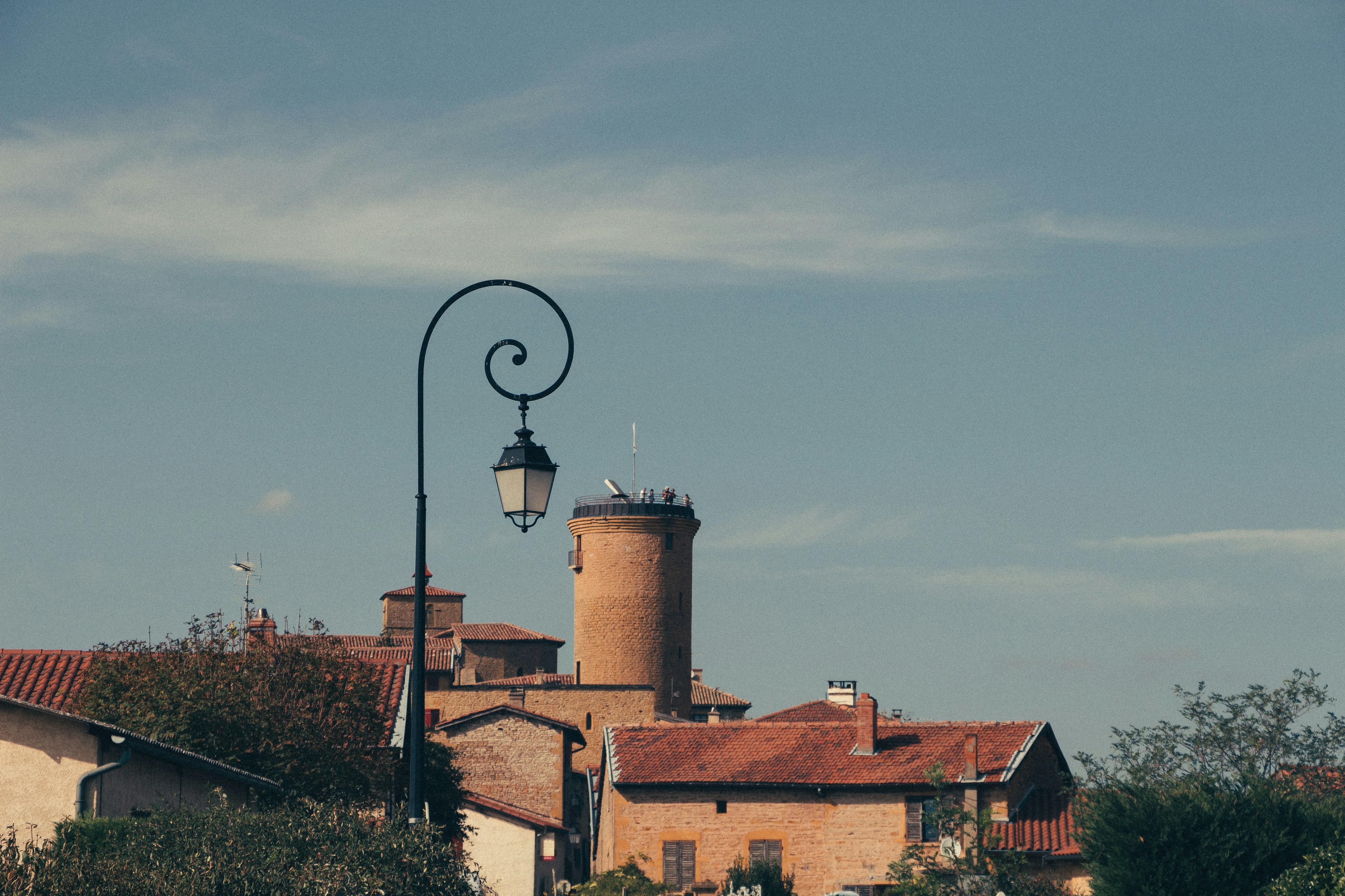 Old Town Lantern Looms Over Red-Tiled Roofs at Dusk
