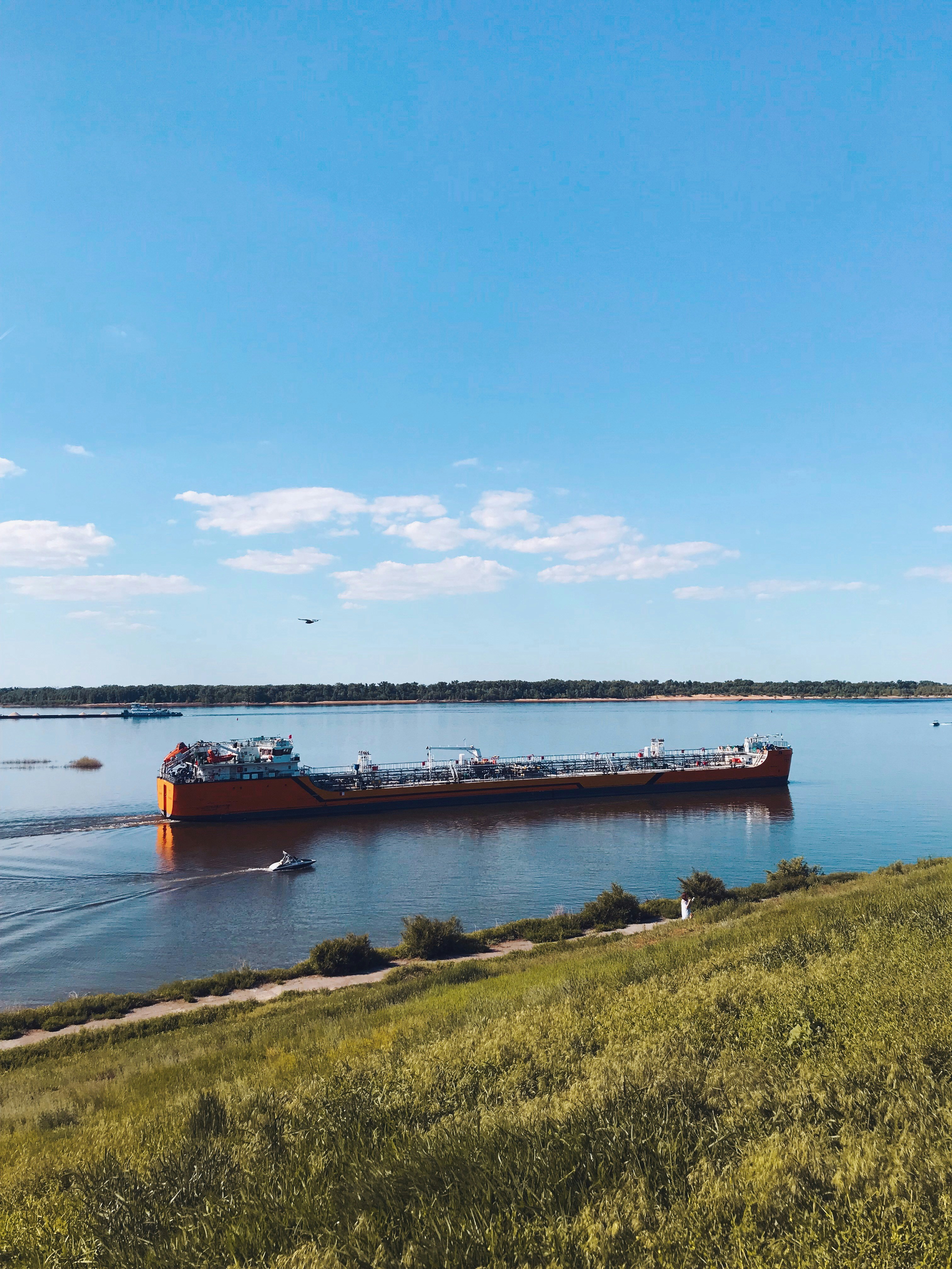 Orange ship in body of water under blue sky photo – Free Blue Image on ...