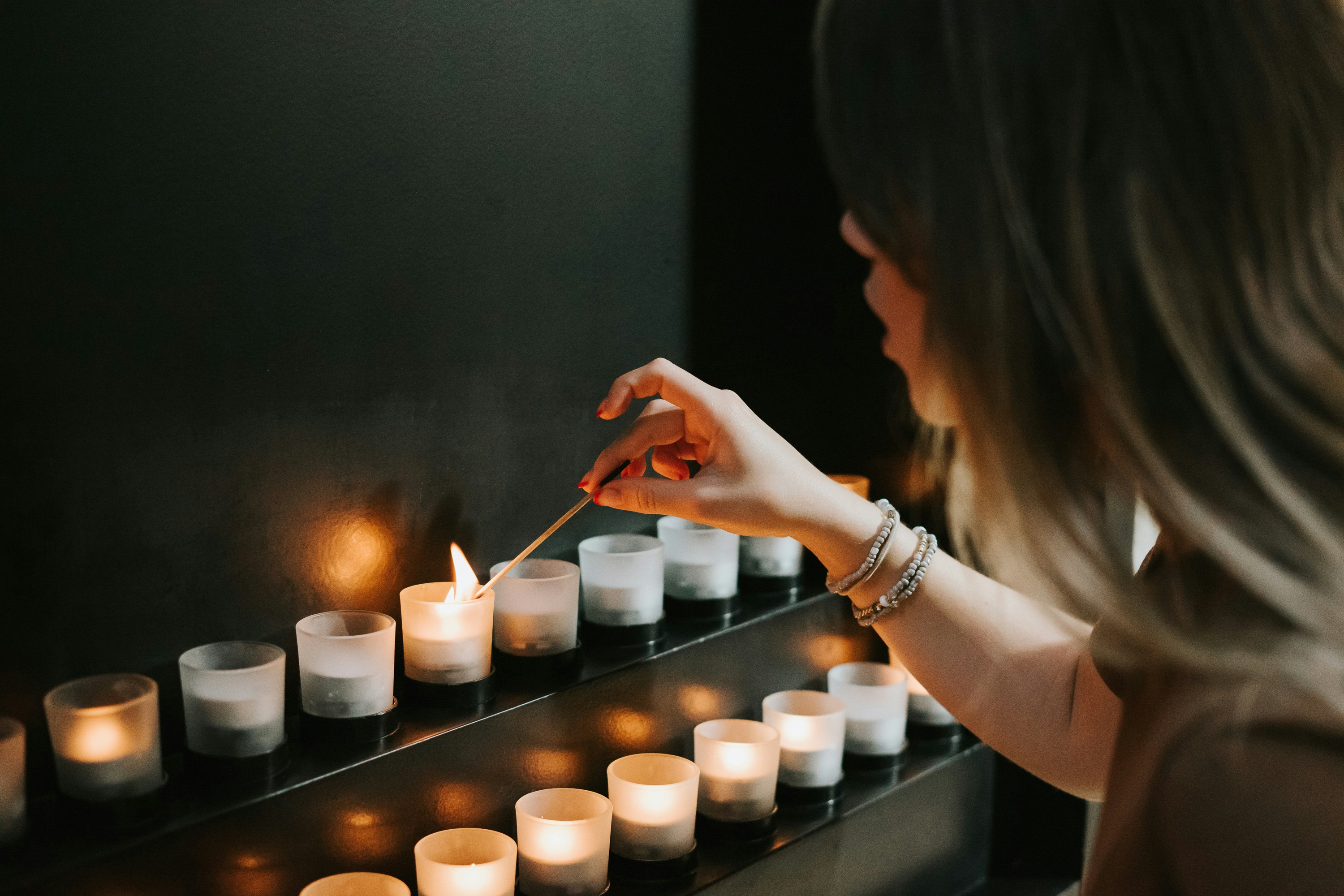 Woman lighting a candle beside candles photo – Free Dc Image on Unsplash