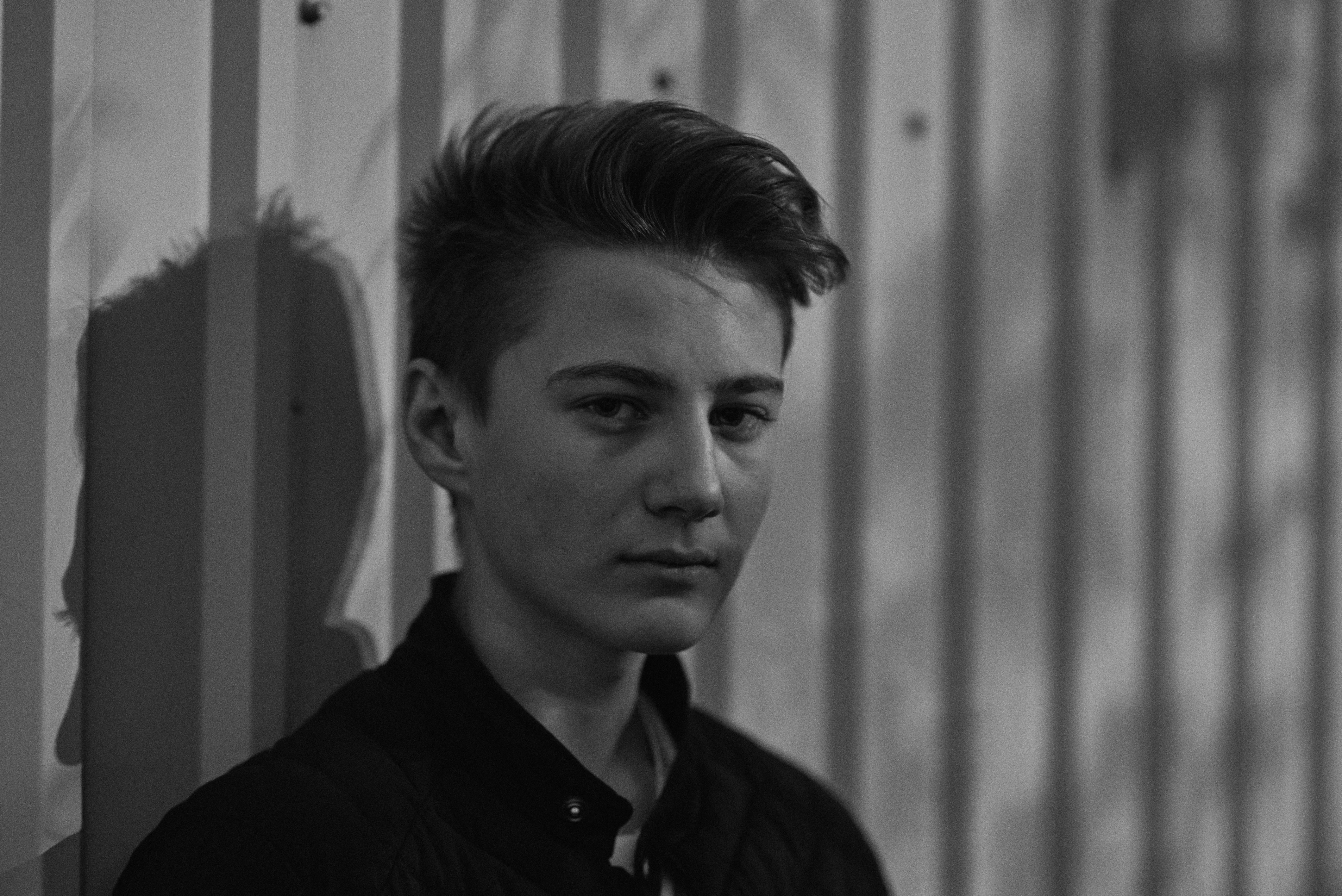 Grayscale portrait picture of man leaning against wall photo – Free ...