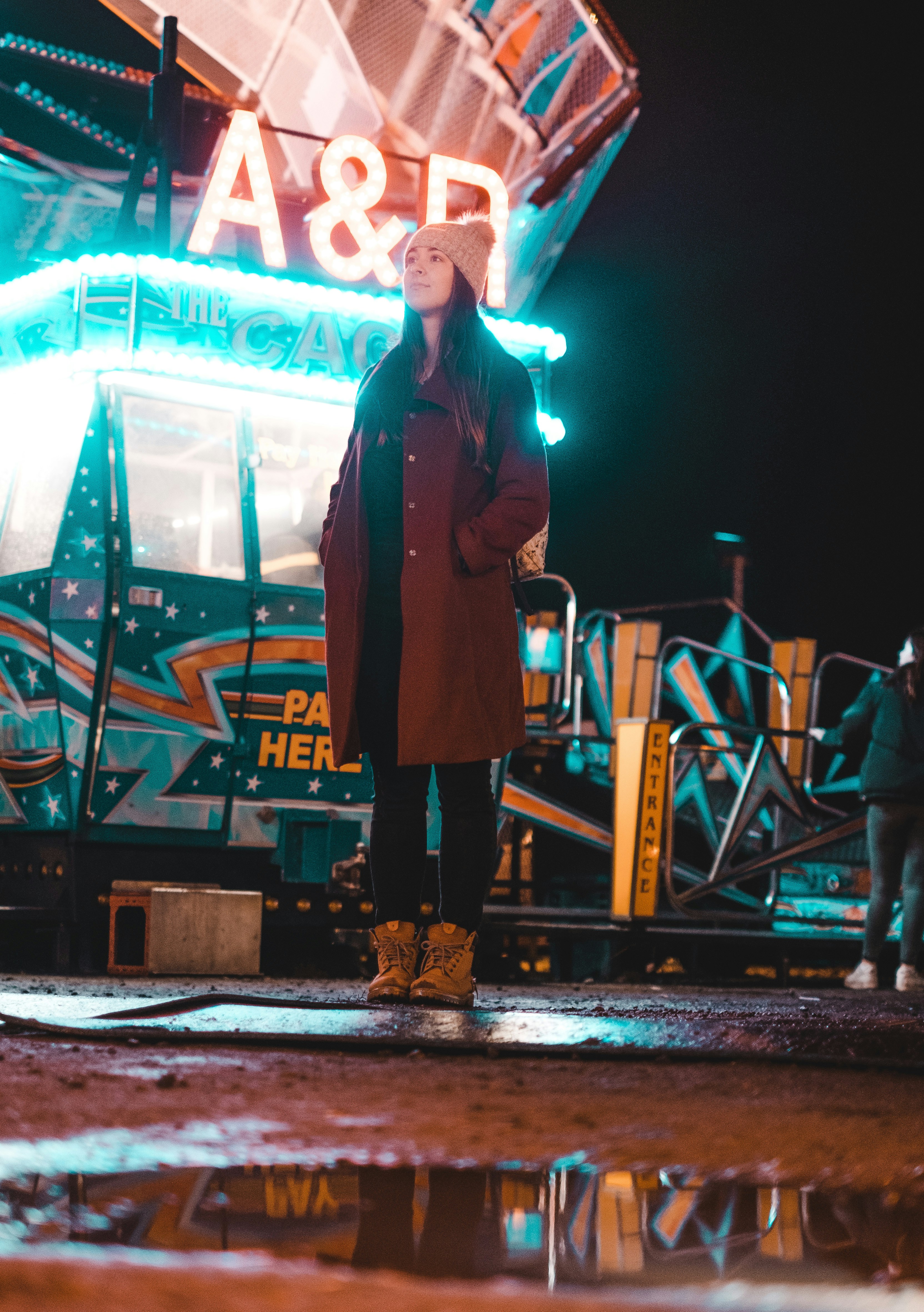 A girl stood next to a carnival ride
