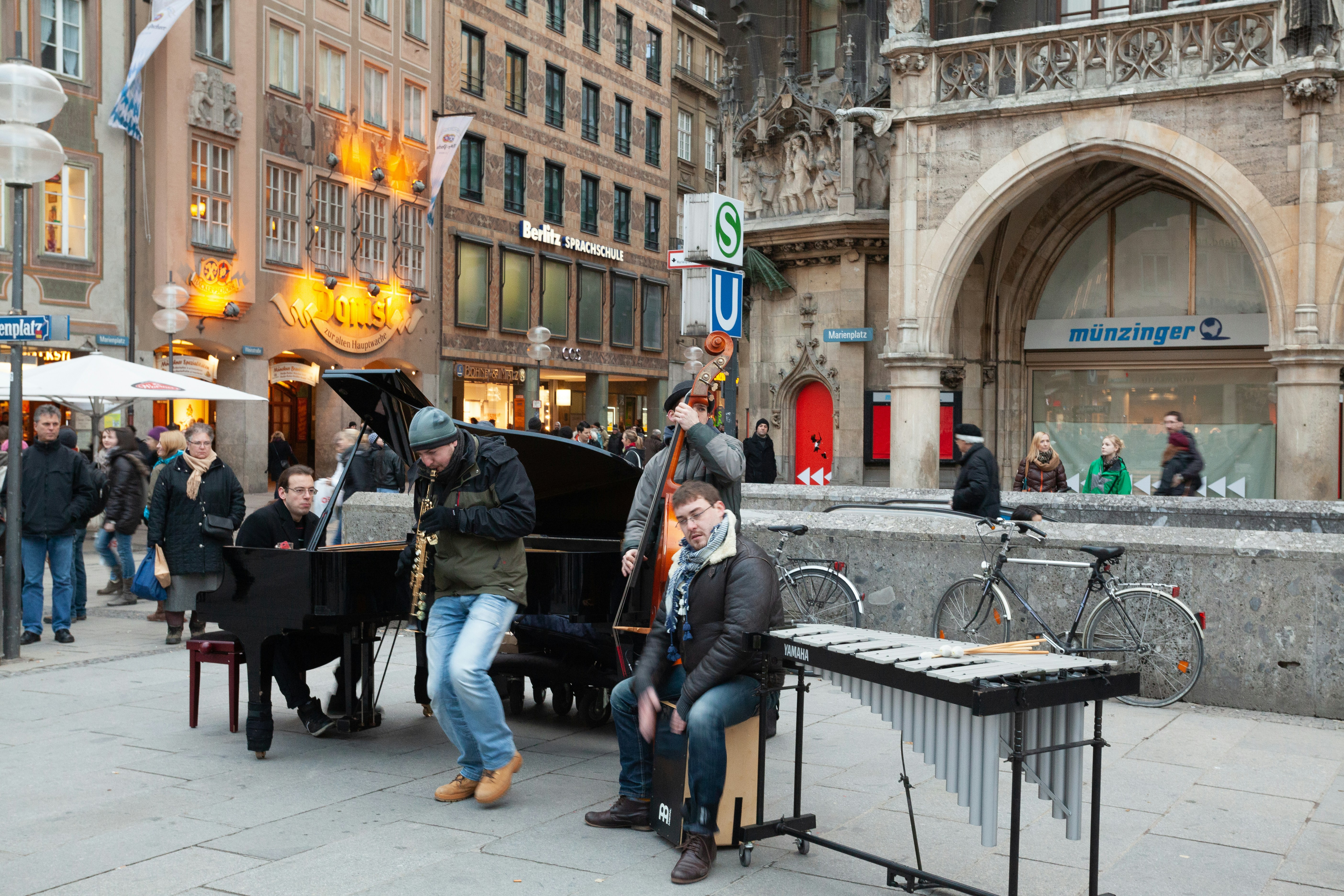 Man in black full-zip jacket sitting beside man playing music ...