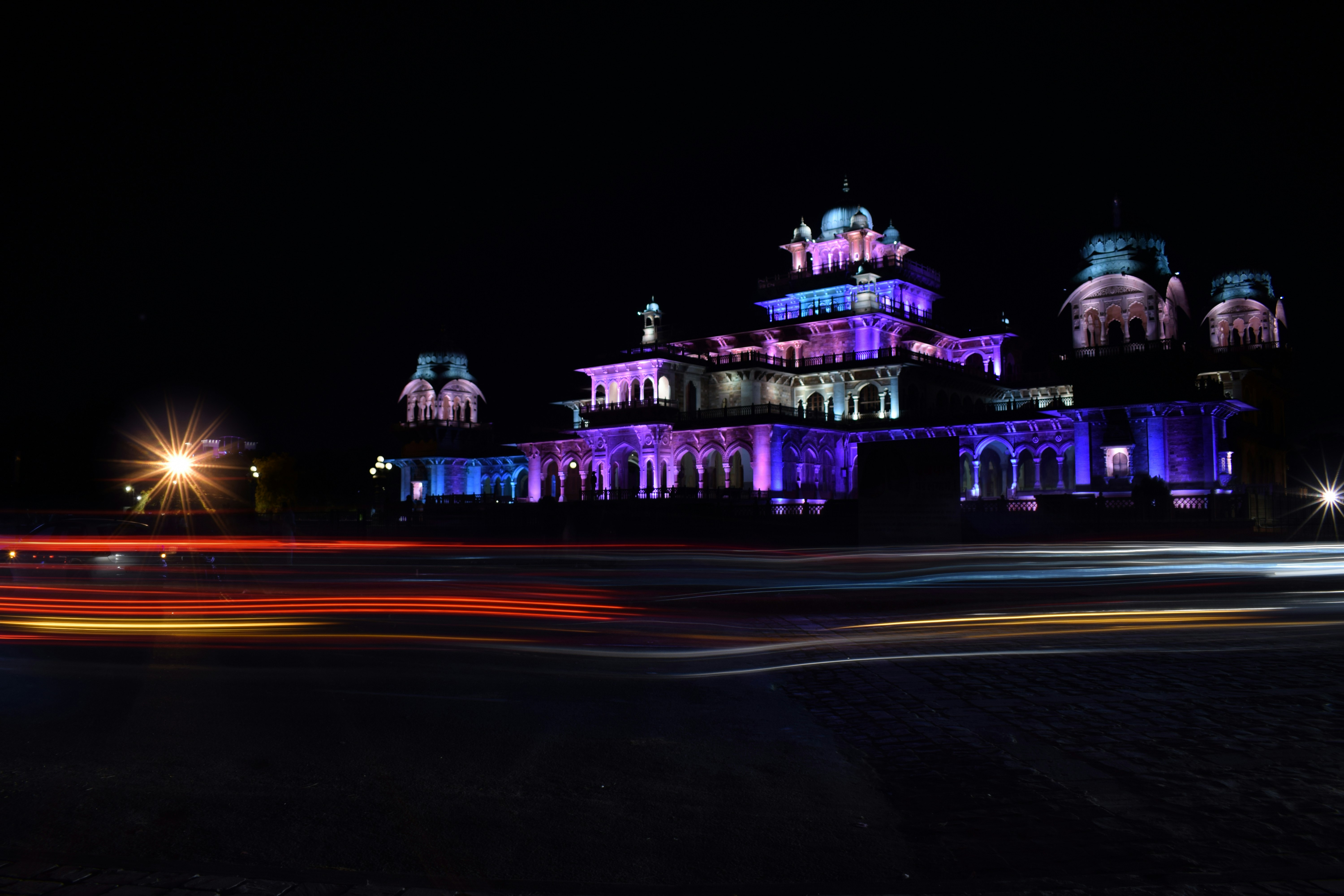 Purple Citadel at Night: A Palace Wrapped in Neon Light and Car Trails