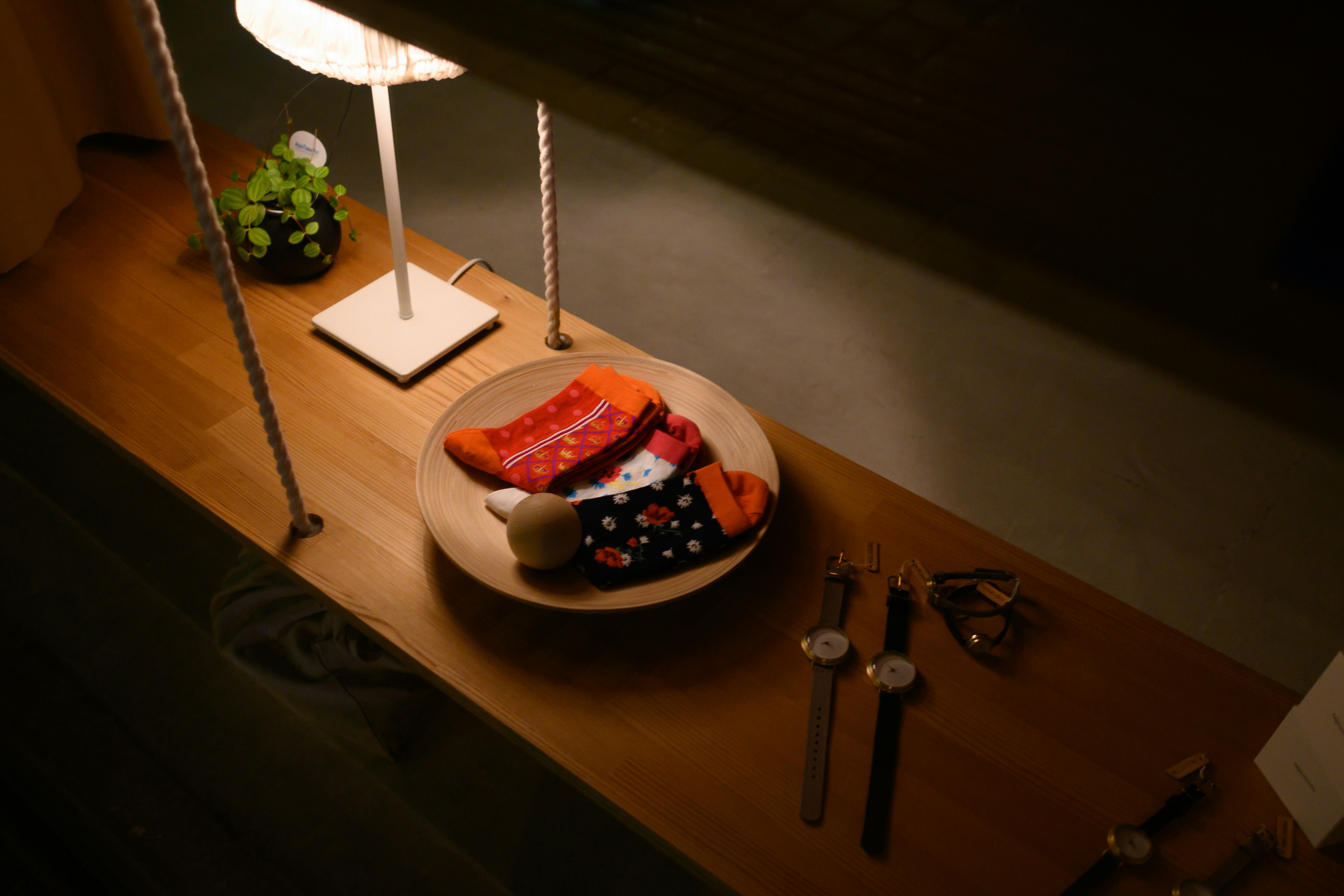 Sock Still Life: Colorful Footwear on a Plate Beneath Warm Lamplight