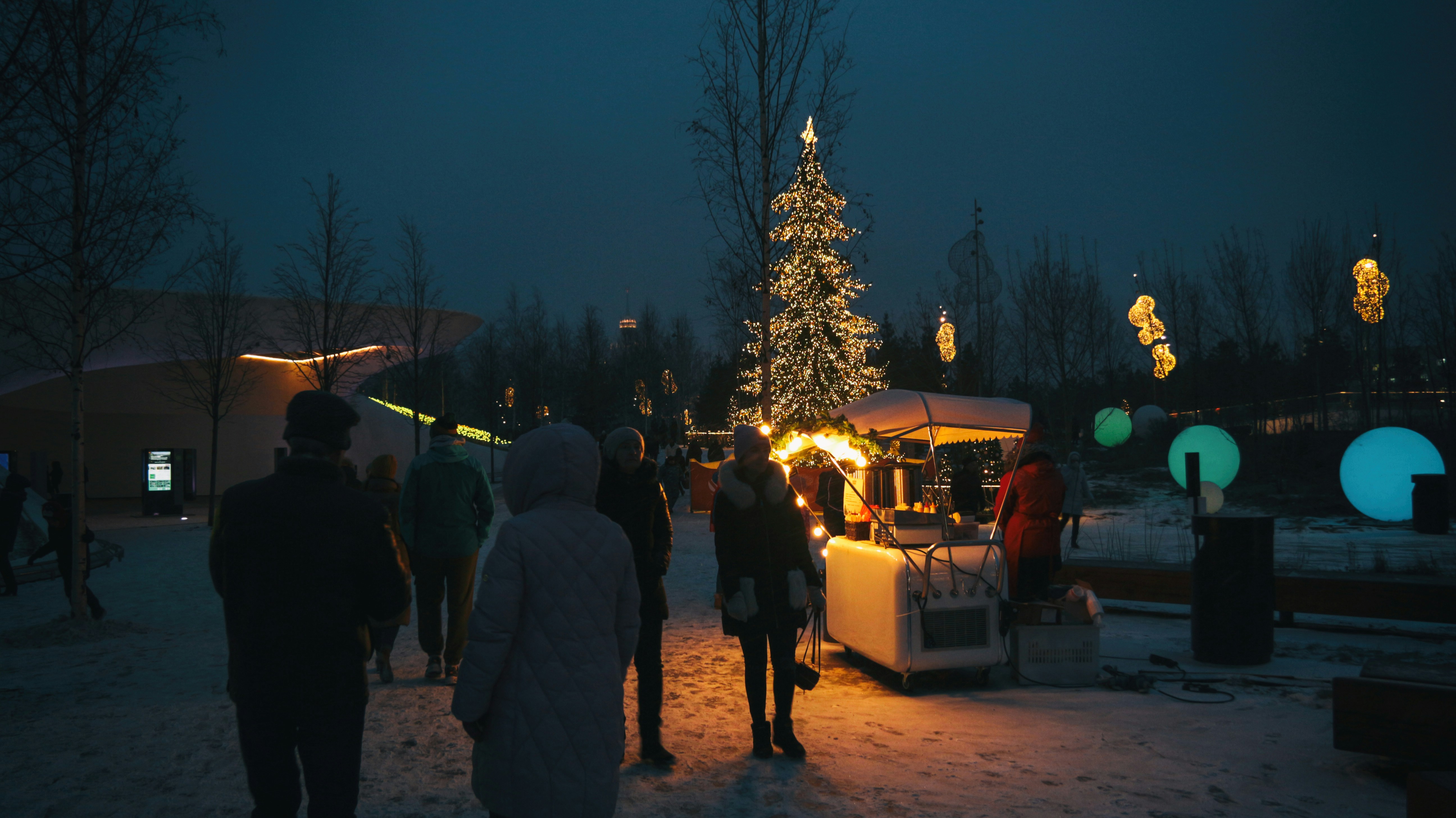 Warm Market Glow by the Snow-Frosted Tree