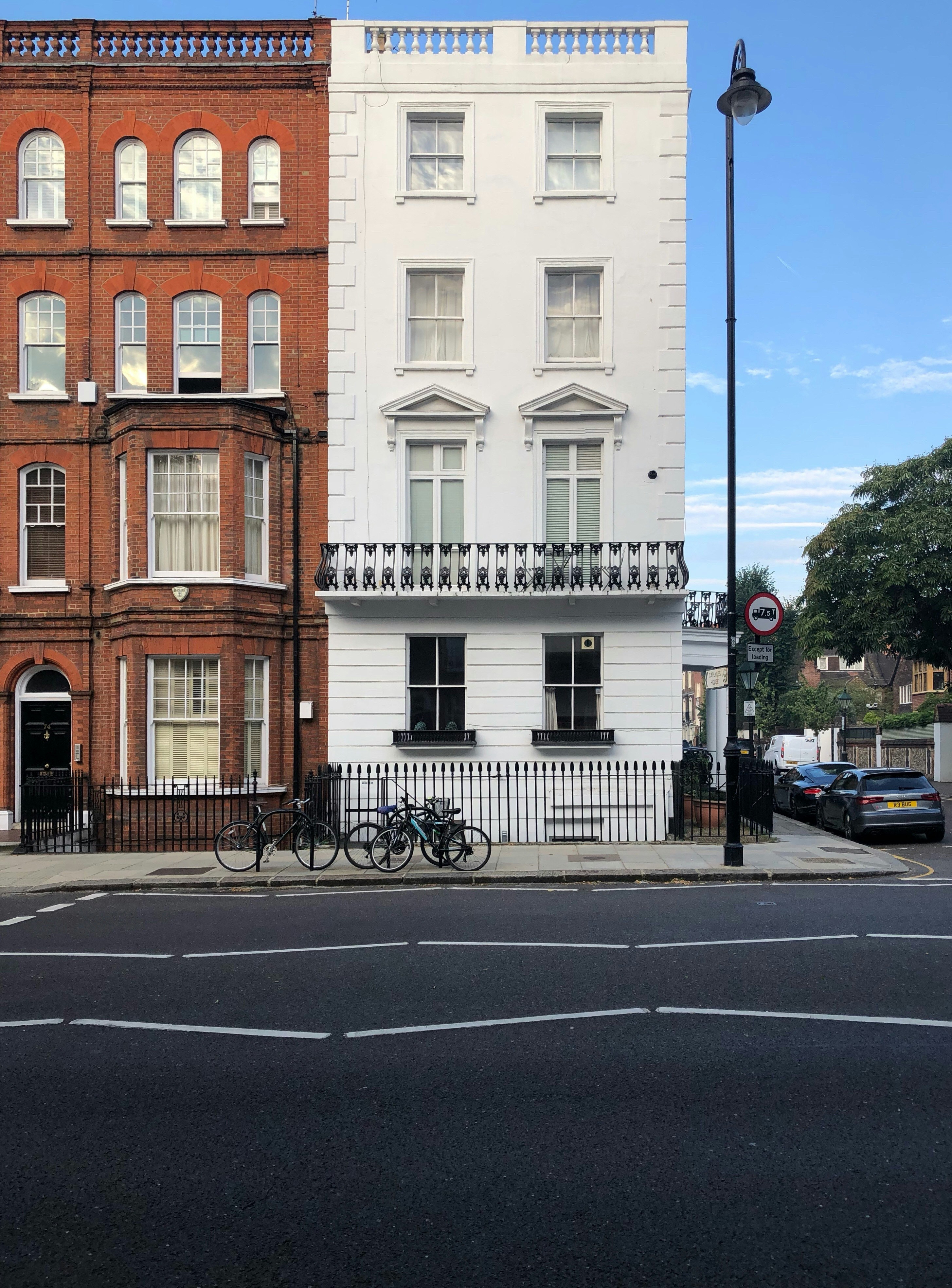 White Terrace Between Brick Facades: A Quiet Street Study