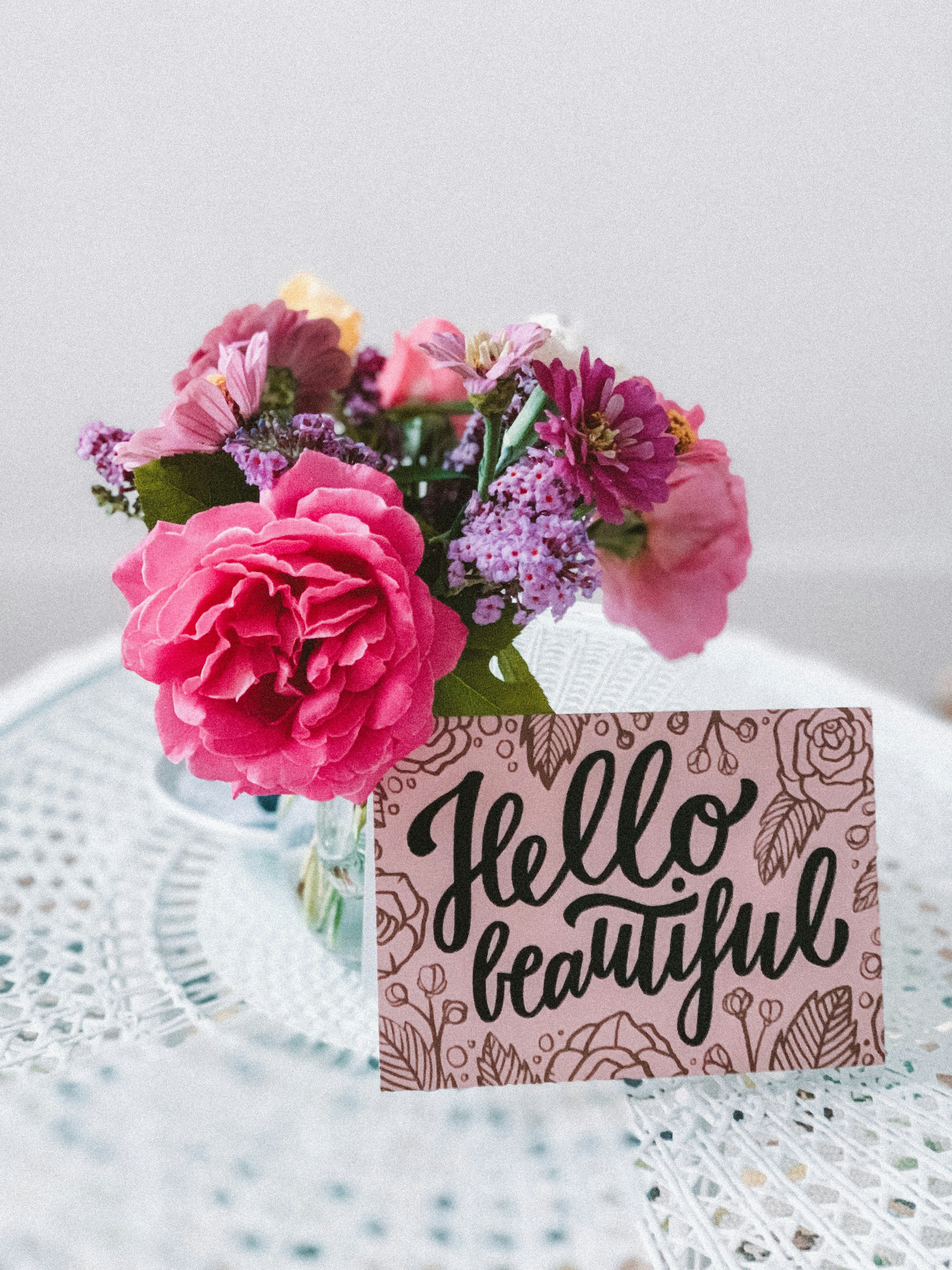 Petals and Prose: A Bouquet Beside a Handwritten Hello Card