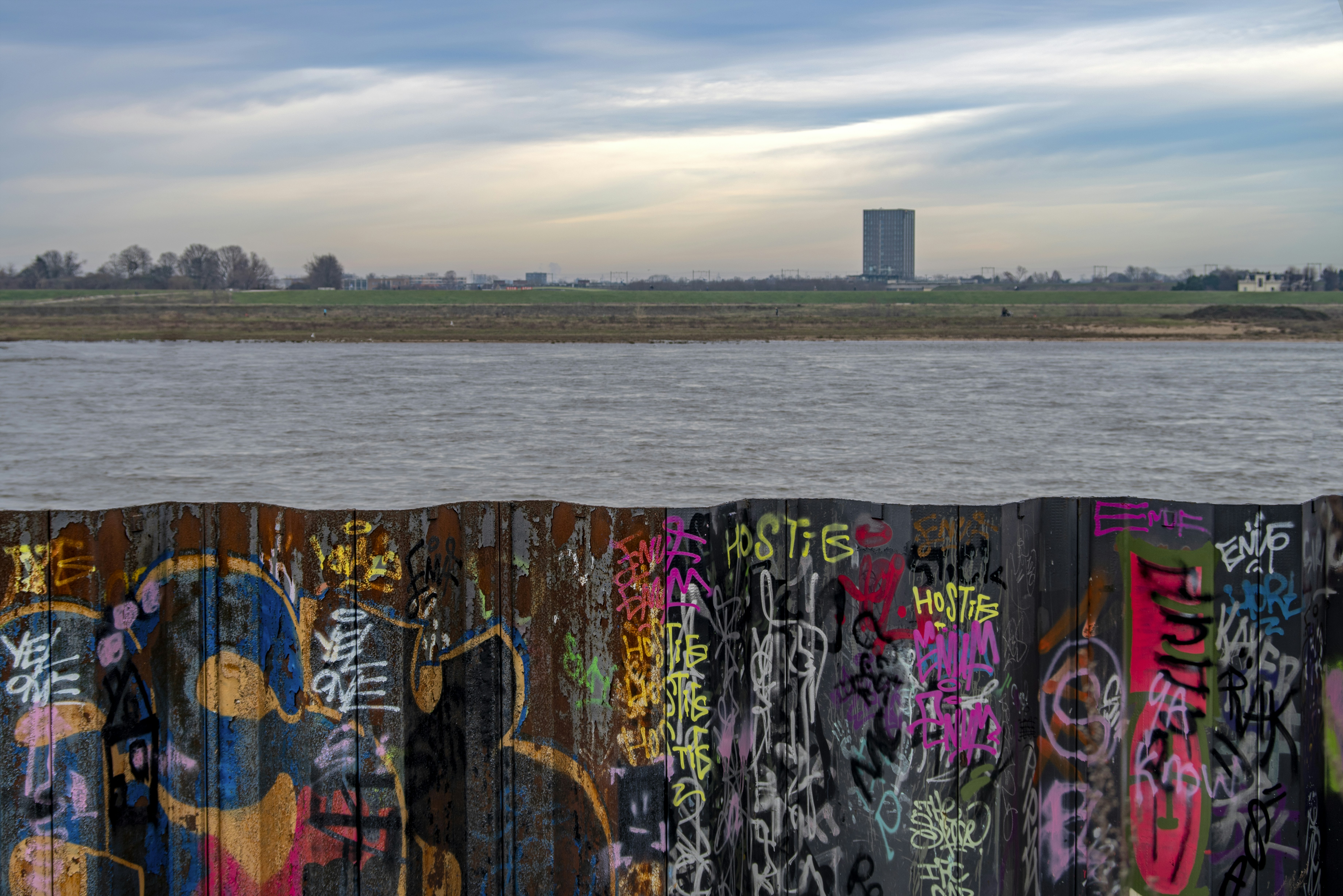 Vivid Graffiti Against a Tranquil Riverbank