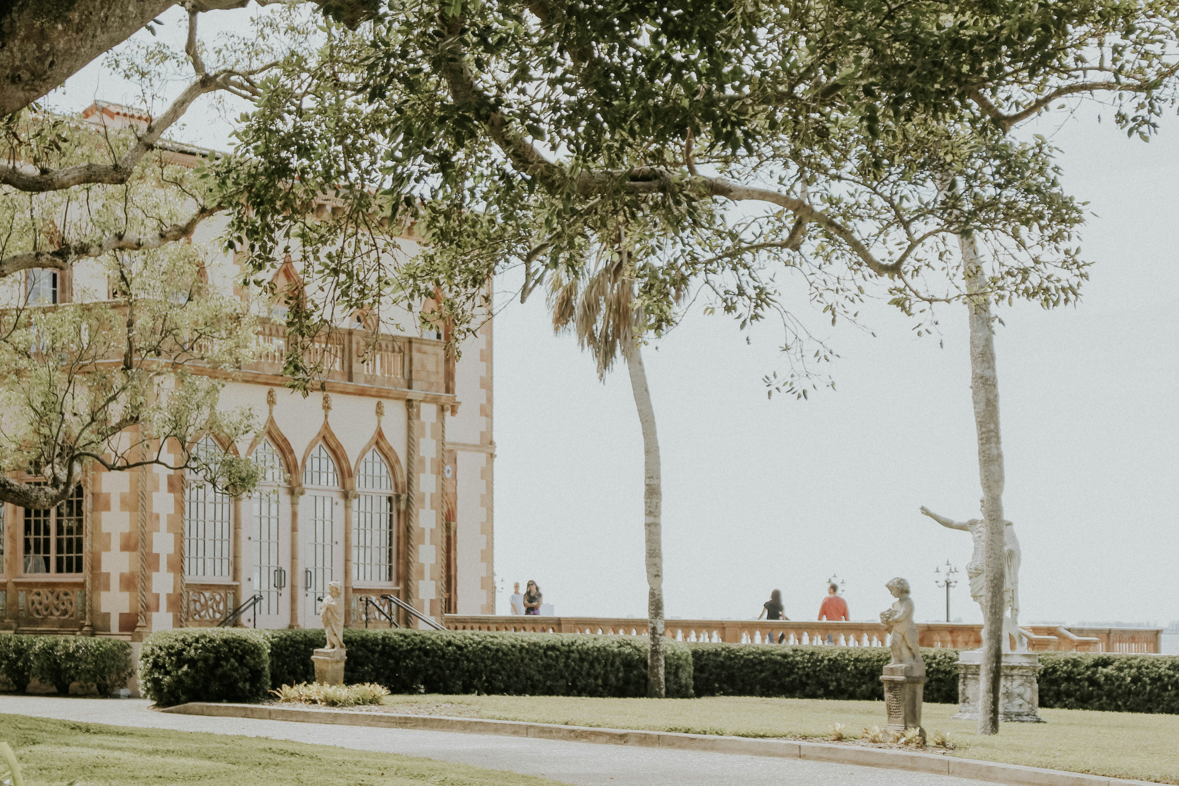 Green trees beside brown building during daytime photo – Free Ringling ...