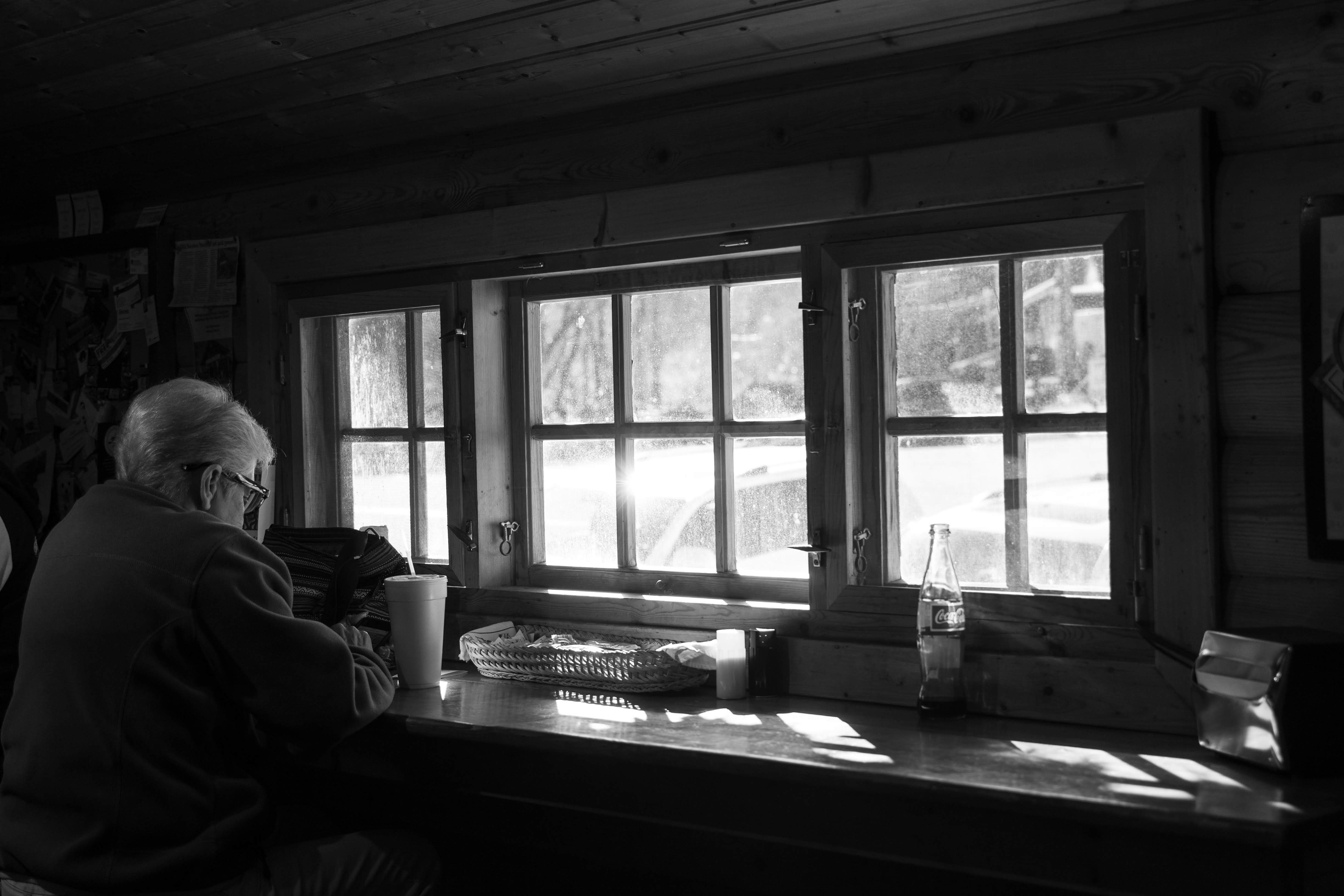a man sitting at a counter in front of a window