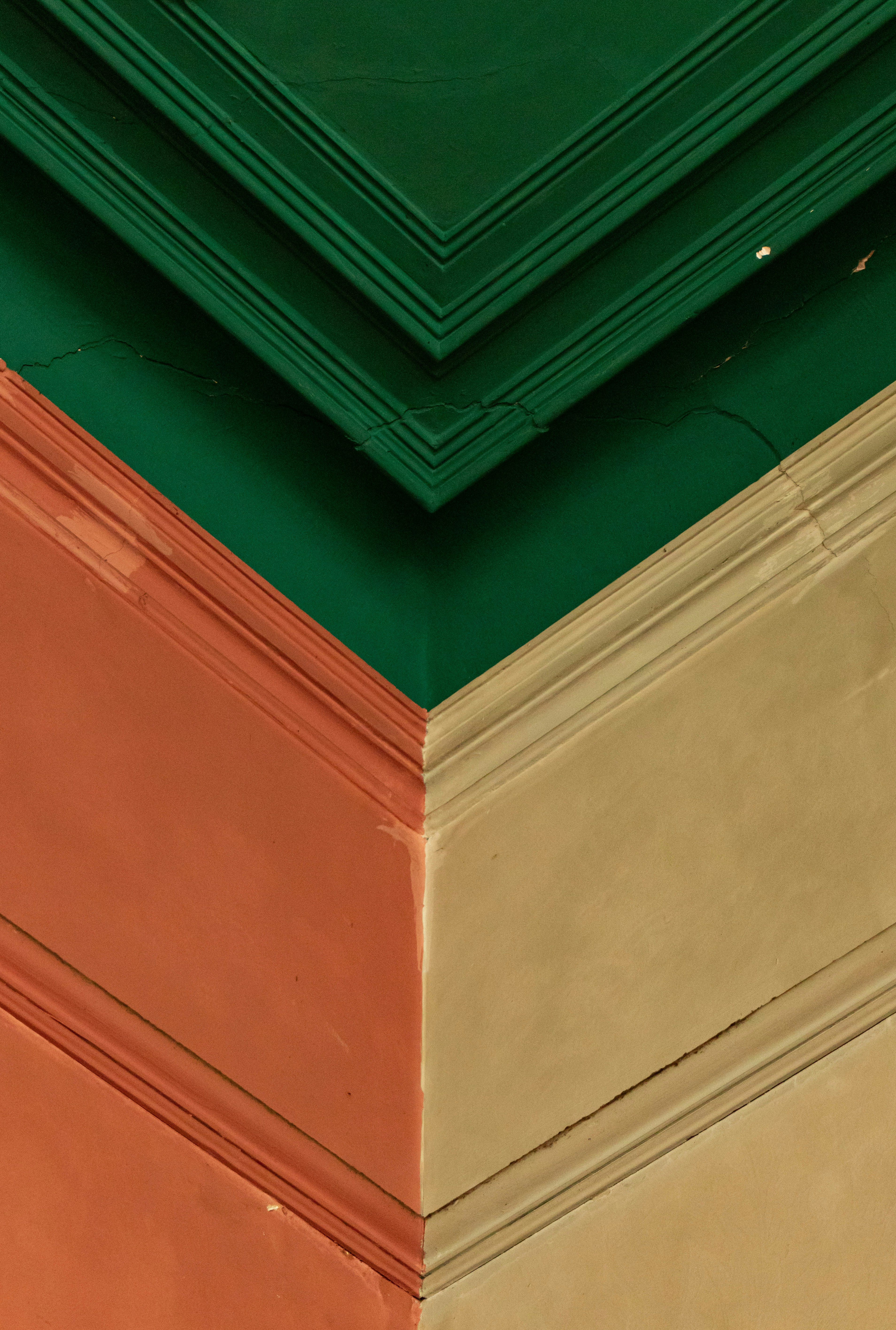 Converging Color Facades: A Triangular Corner in Green, Coral, and Sand