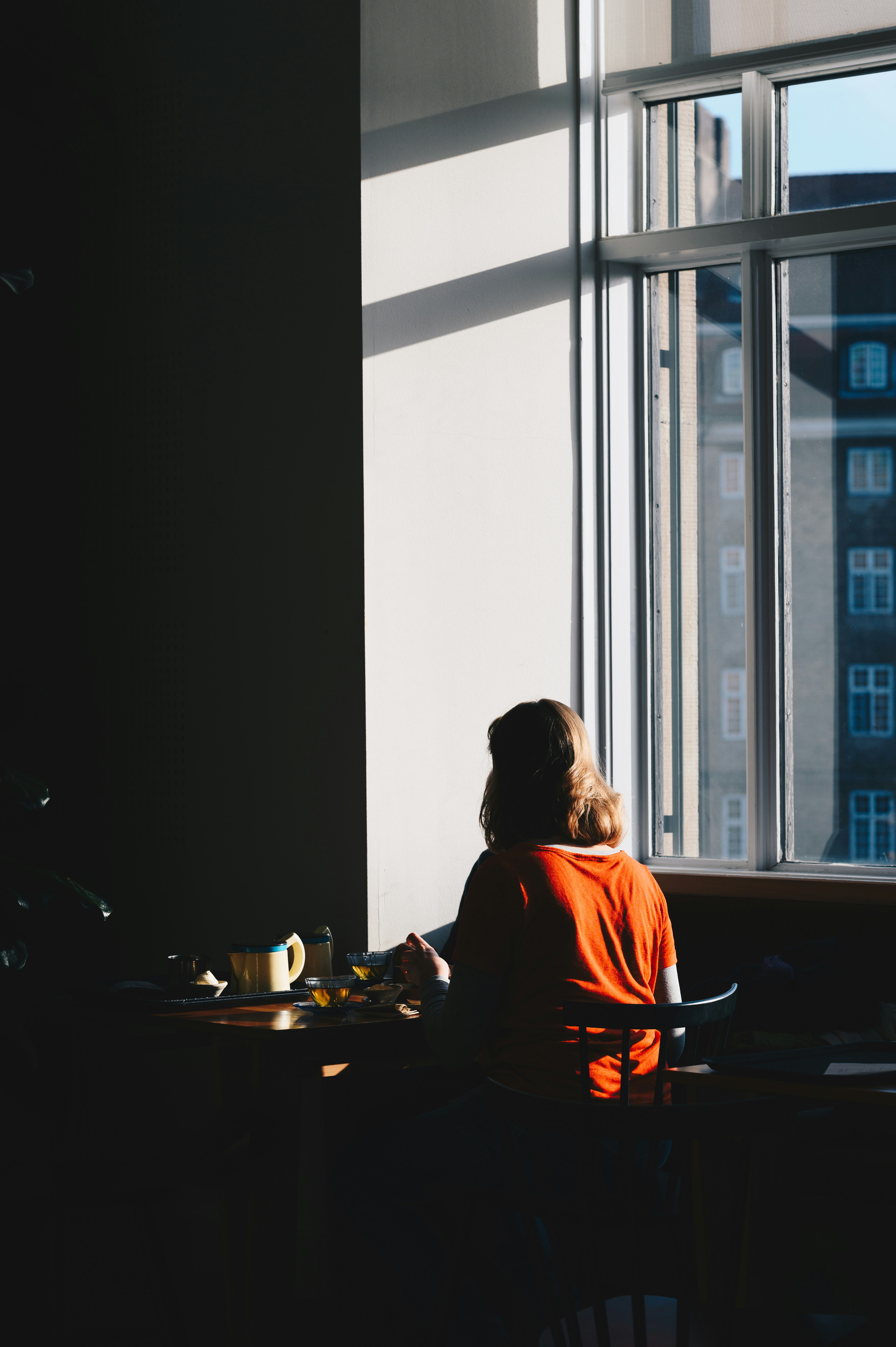 Woman sitting on chair next to window photo – Free Copenhagen Image on ...