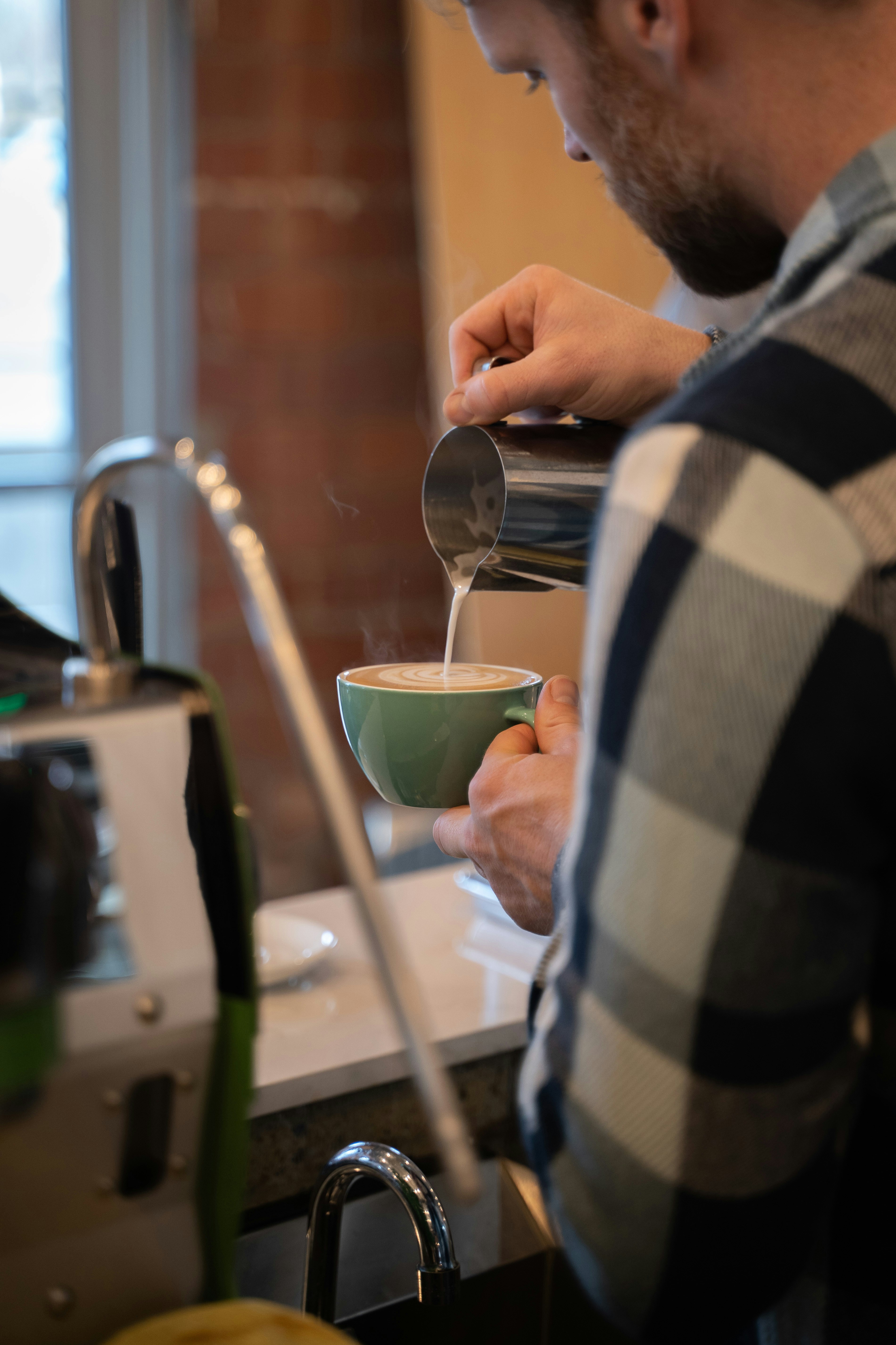 Pour Precision: Milk Streams into a Mint Green Cup