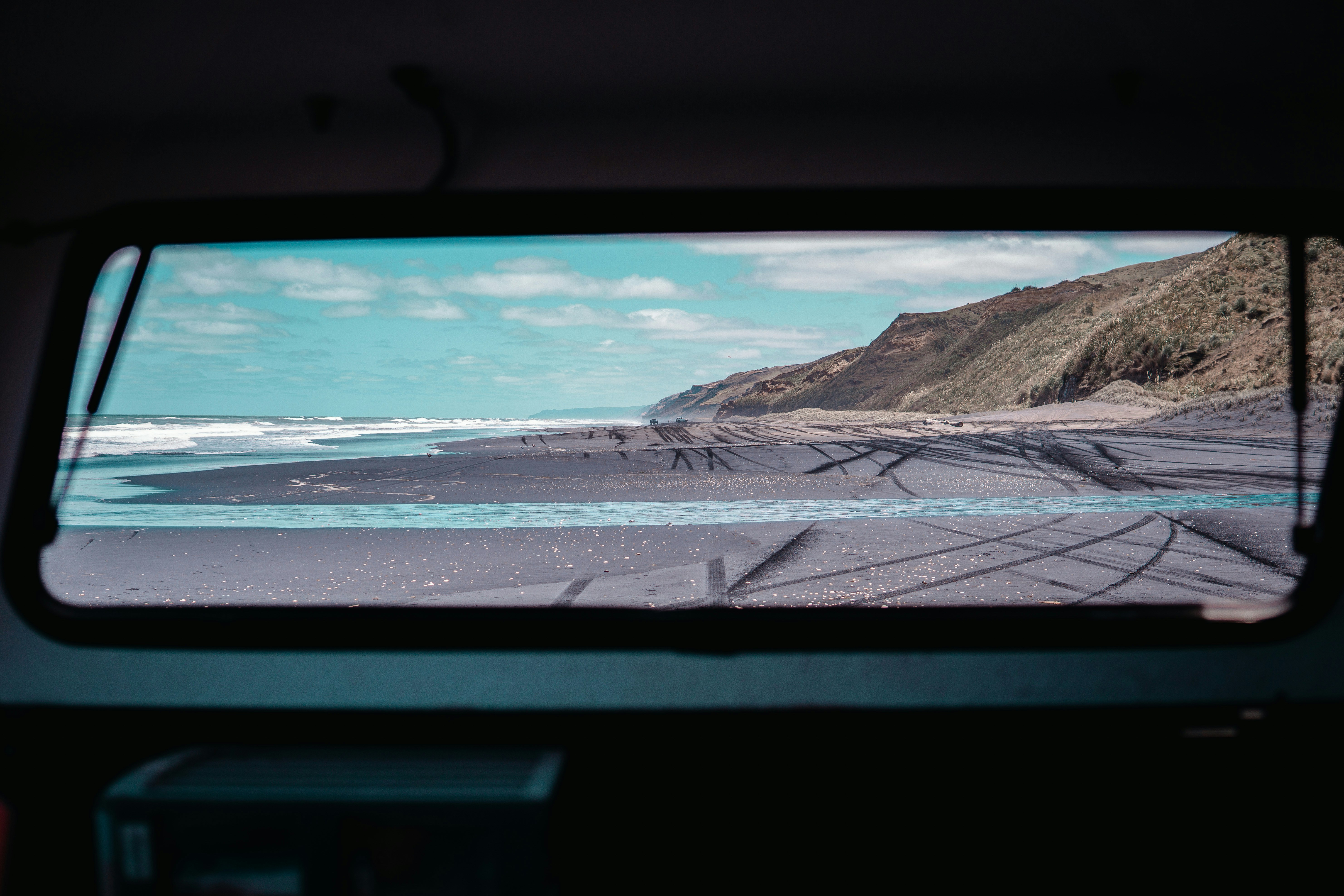 Framed Coastline: Dunes, Sea, and Sky Through a Vehicle Window