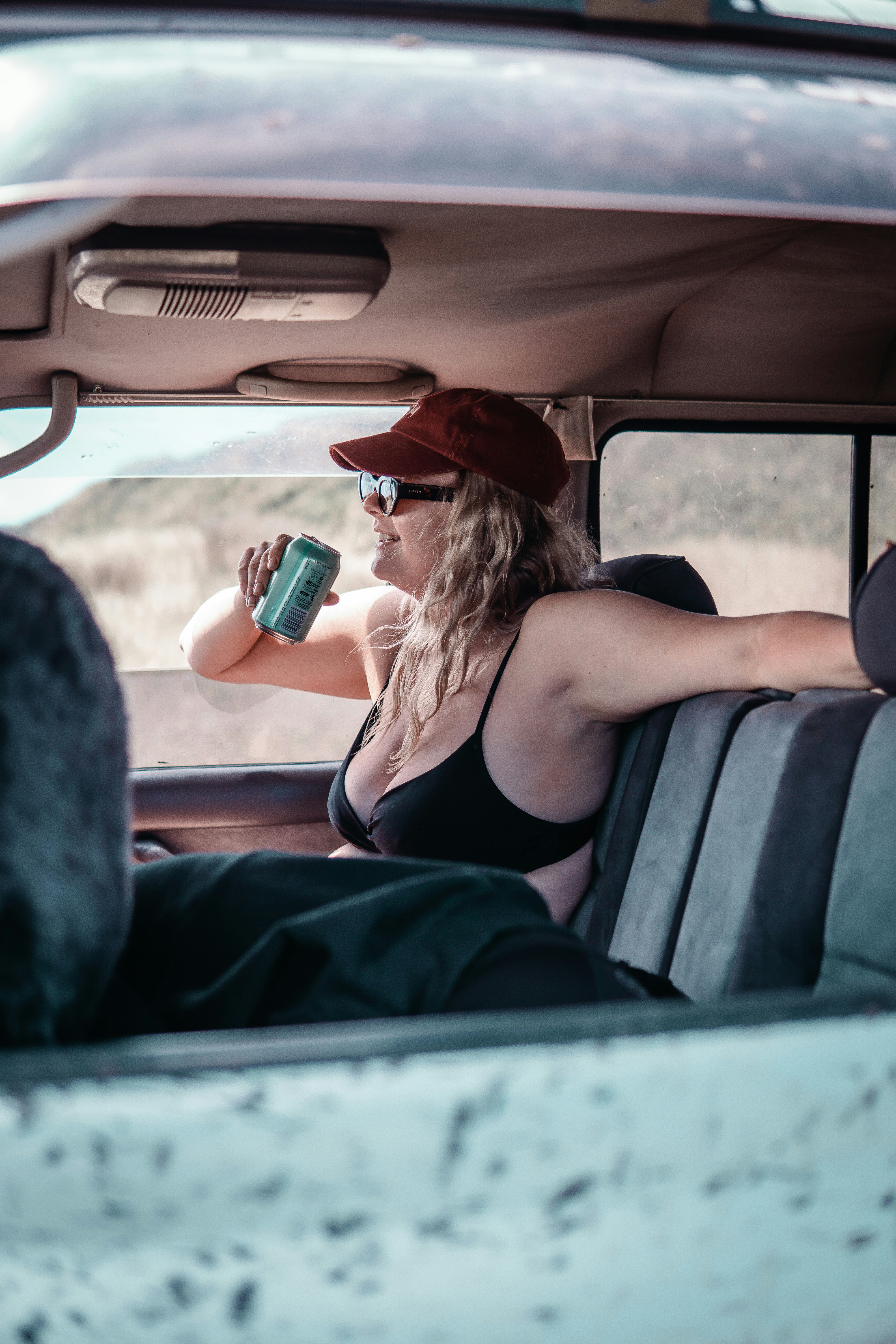 Dusty Desert Drive: A Red-Cap Portrait Inside a Weathered Car