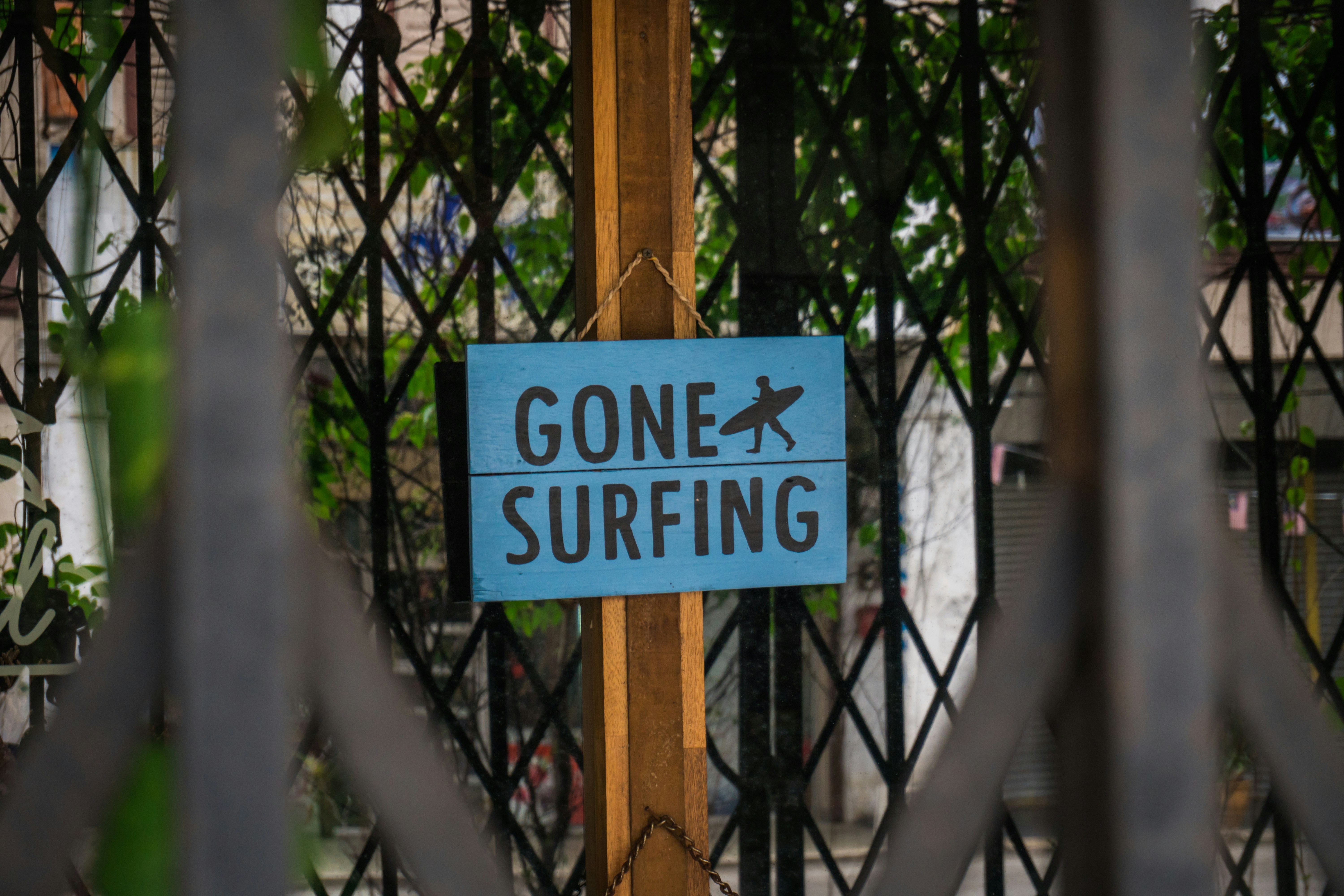 Gone Surfing: A Blue Sign Framed by Crisscrossed Metal and Wood