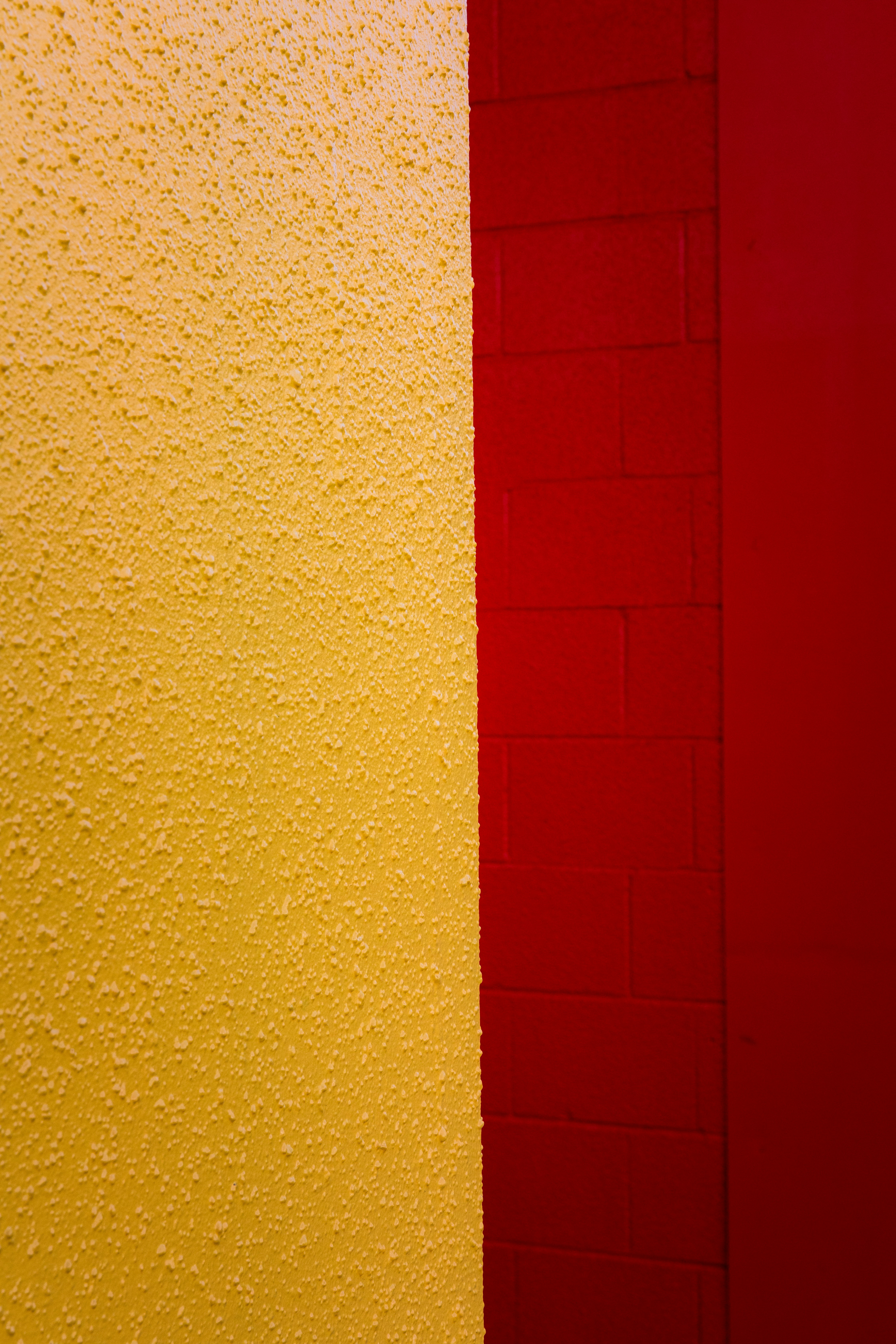 Edge of Color: A Yellow Stucco Wall Bordered by a Crimson Panel