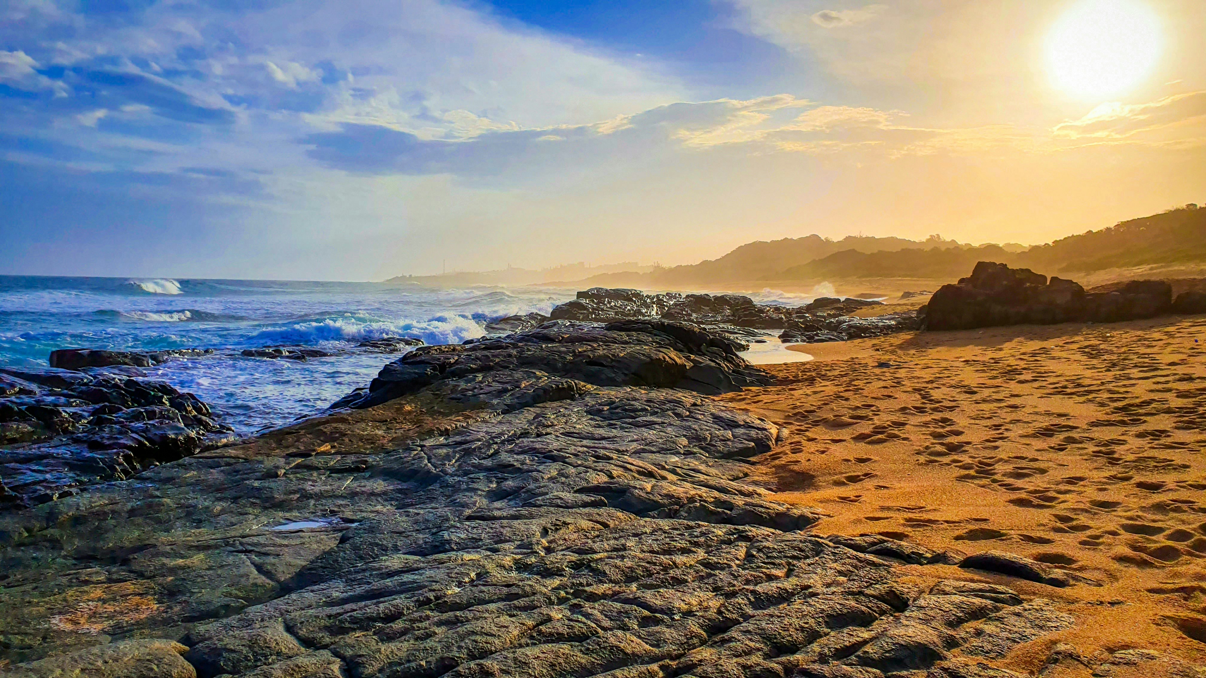 Sunlit Tidebreak: Weathered Rocks and Golden Shore