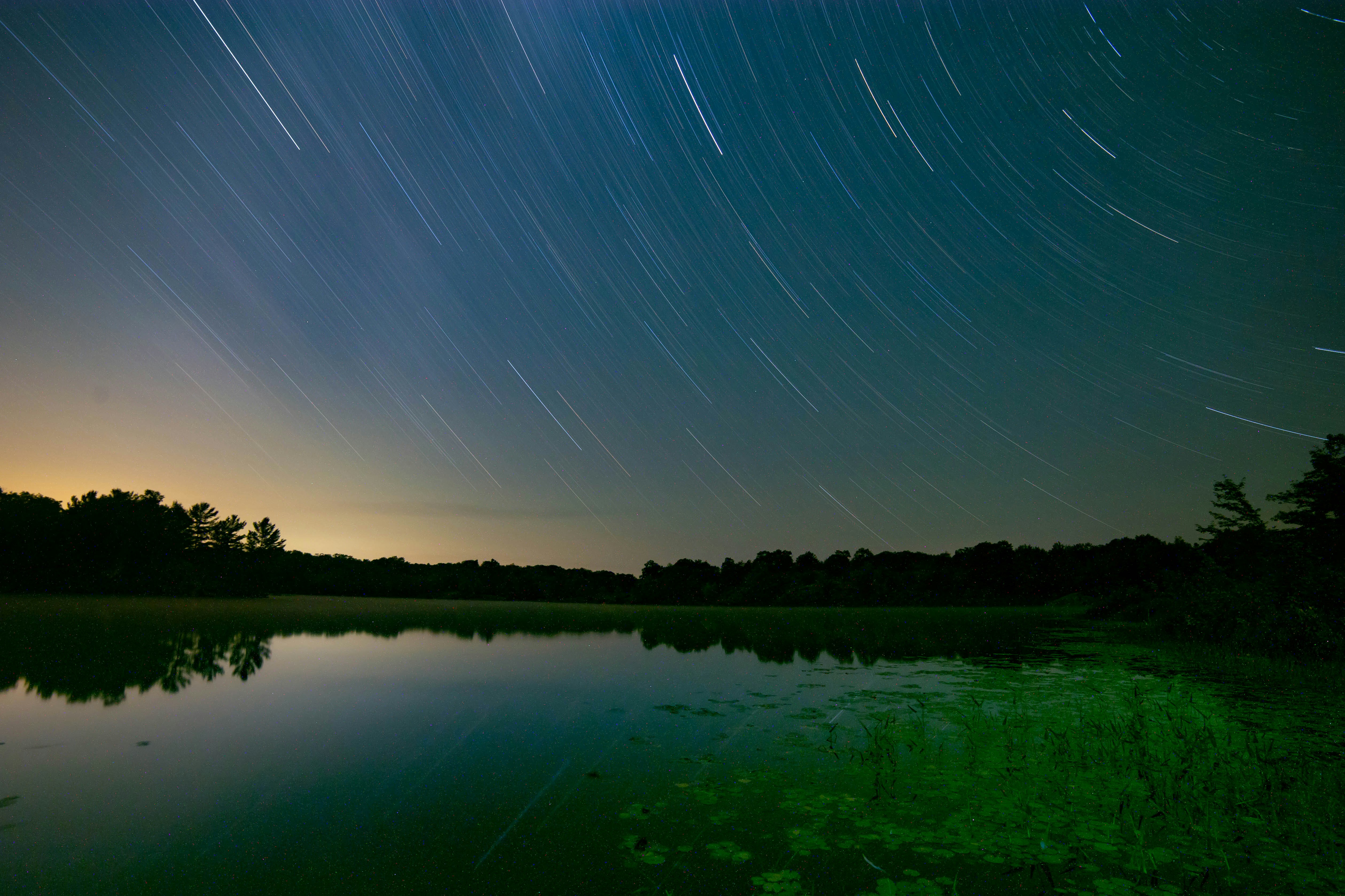 Star Arcs Over a Quiet Lake: A Midnight Long-Exposure Scene