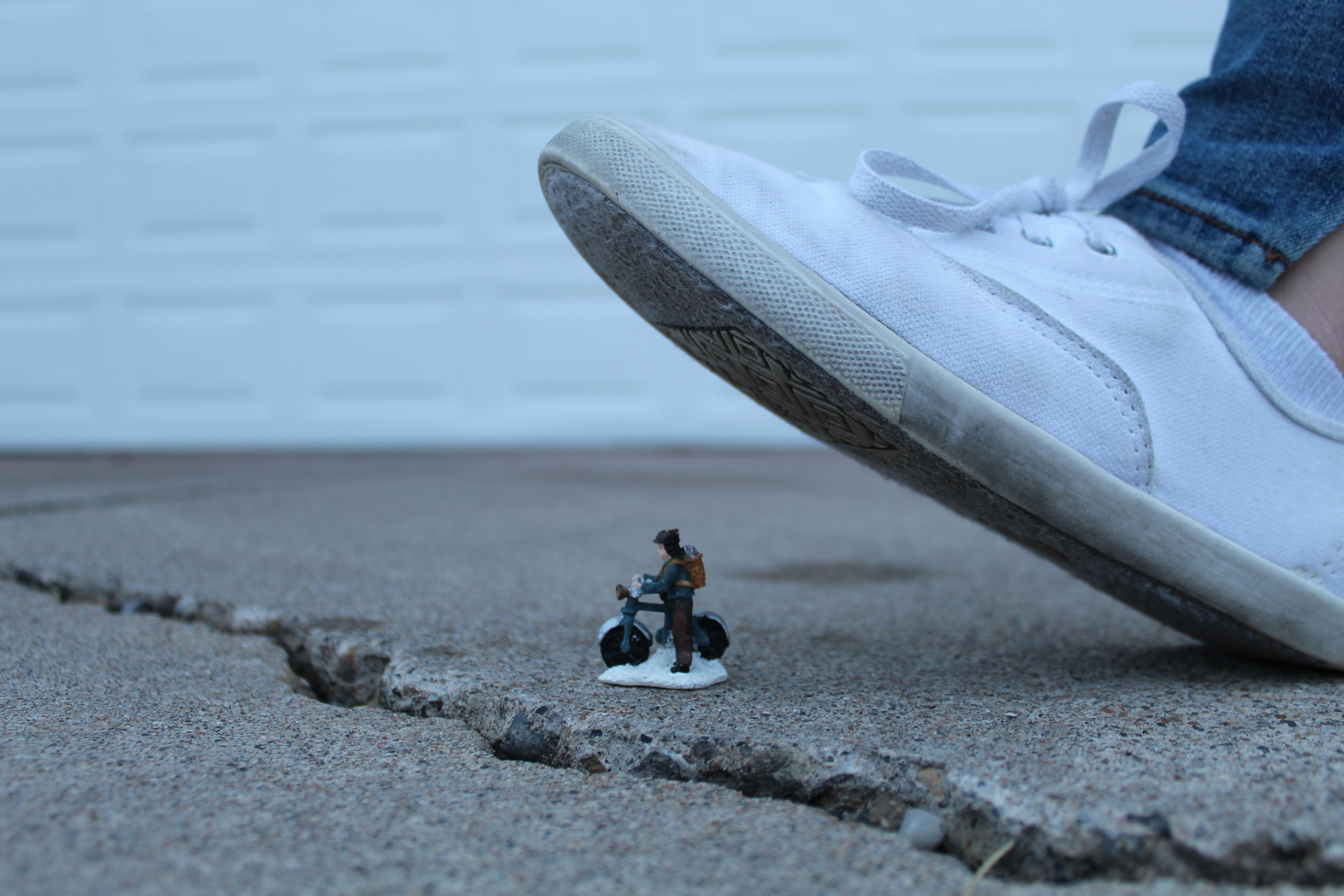 Tiny Rider, Big Scene: A Miniature Motorcyclist Beside a Sneaker Footprint