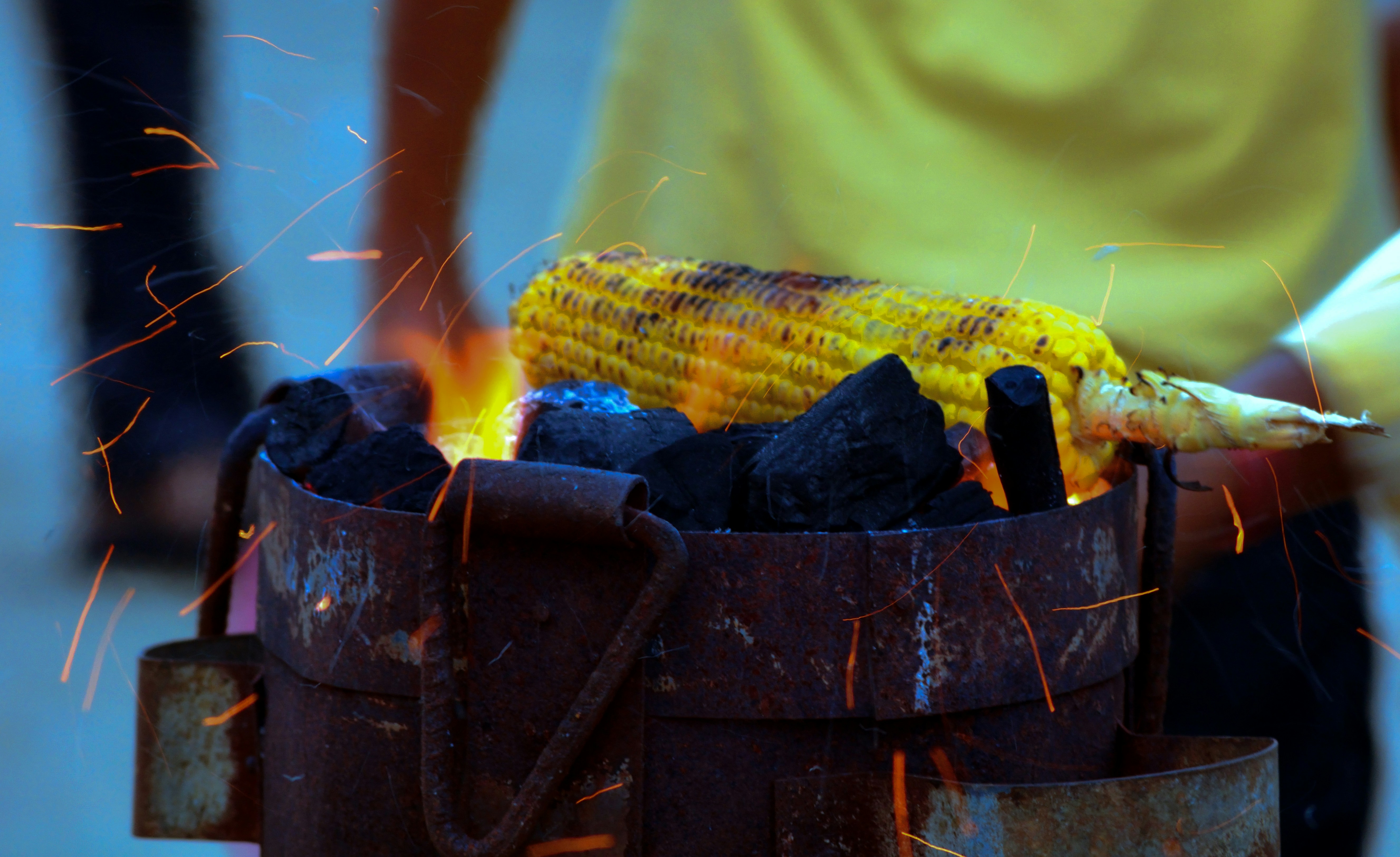 Charred corn searing atop a rustic grill