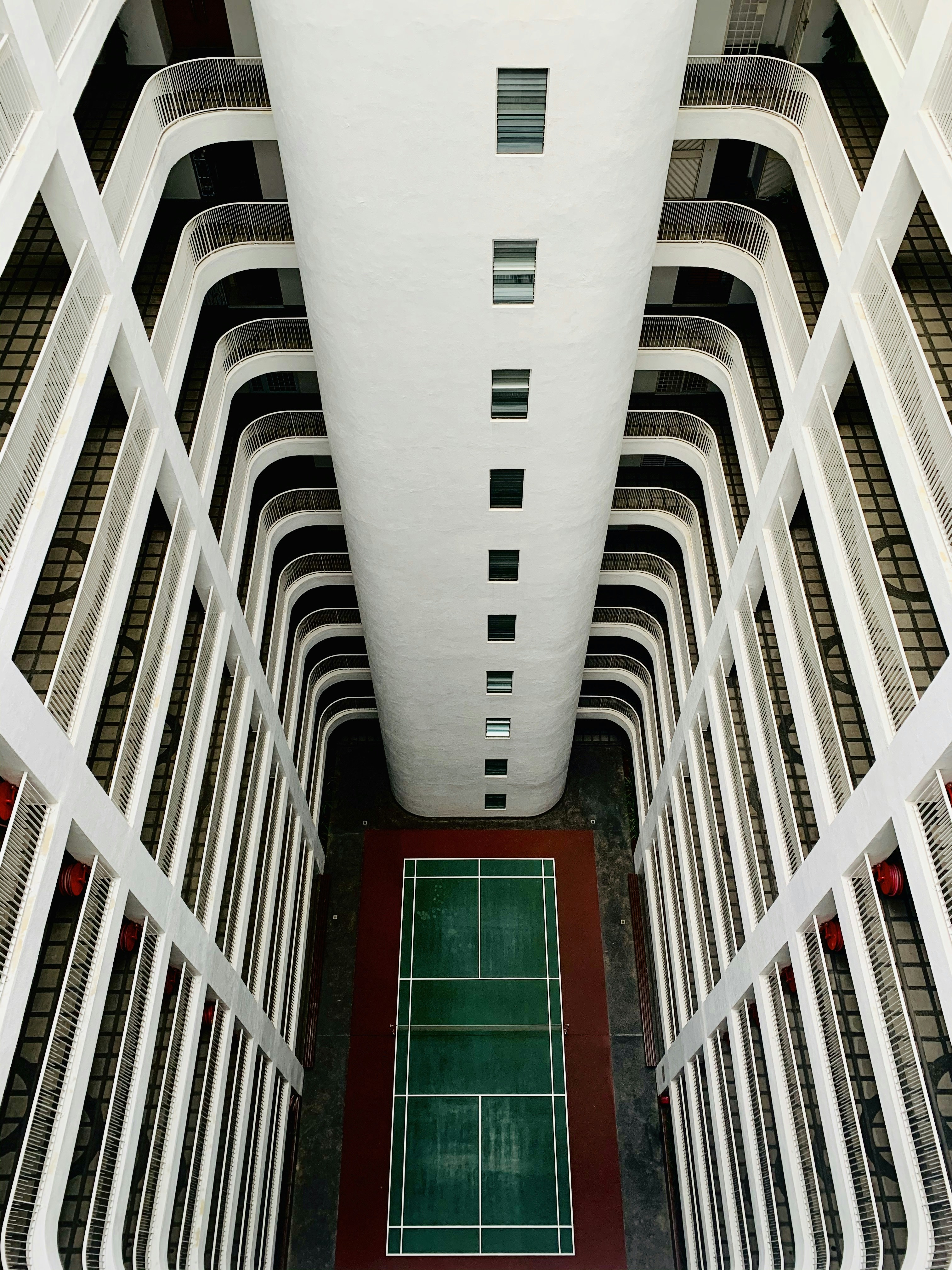 Vertical Echoes: A Monolithic Atrium Framing a Green Court