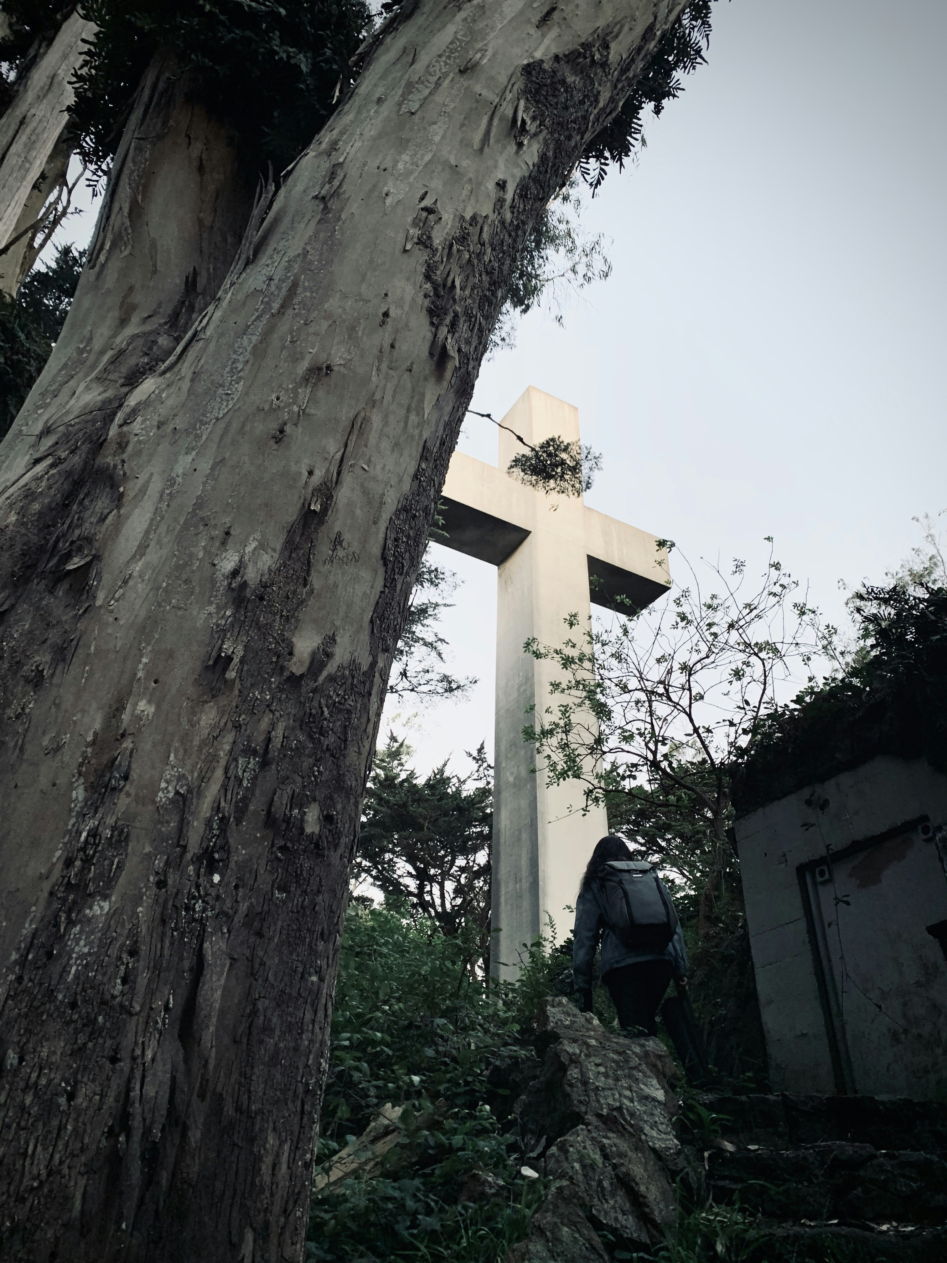 Between Stone and Sky: A Hiker's Ascent Beneath a Quiet Cross