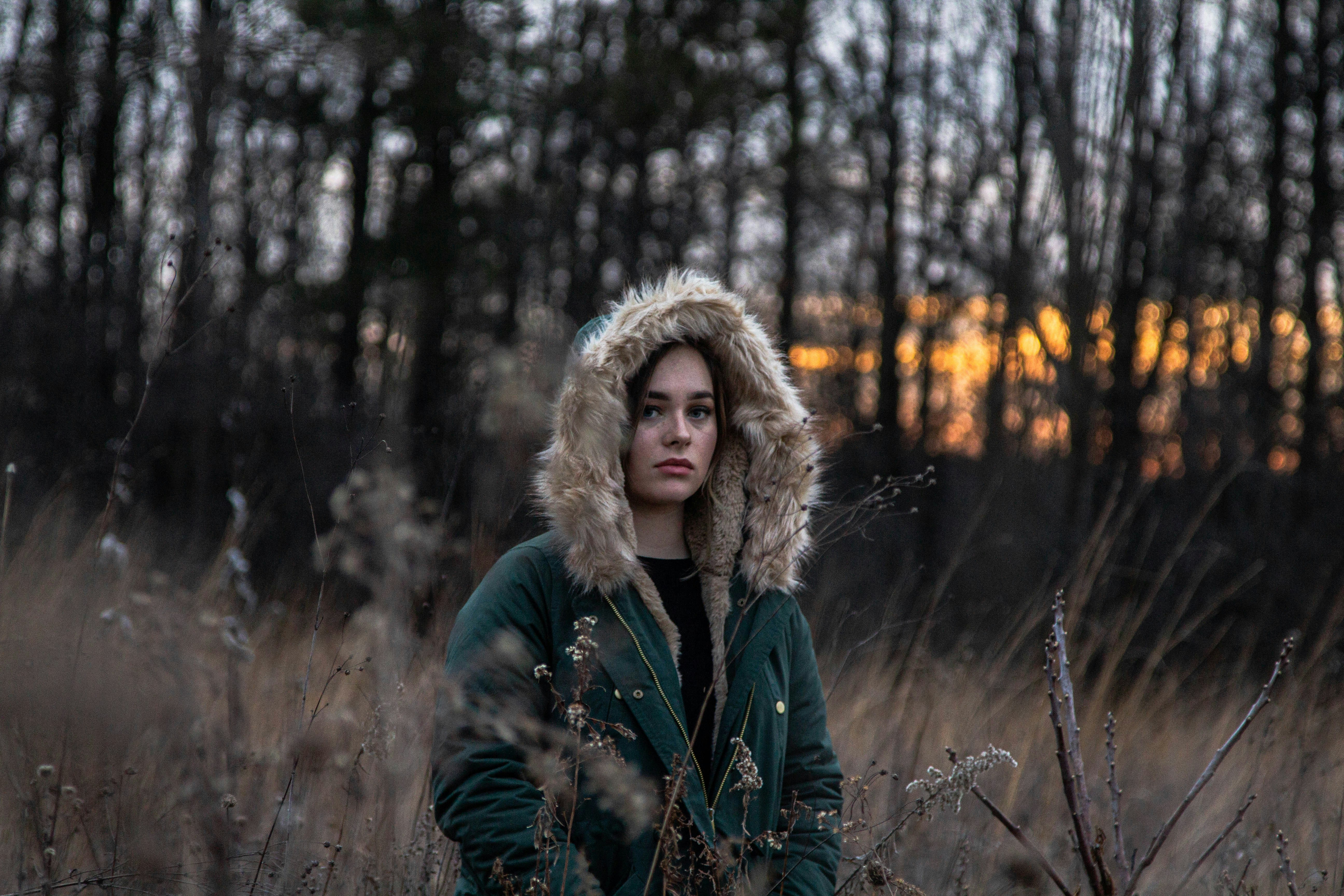 Dusk in the Tall Grass: A Fur-Hooded Portrait on the Edge of the Woods