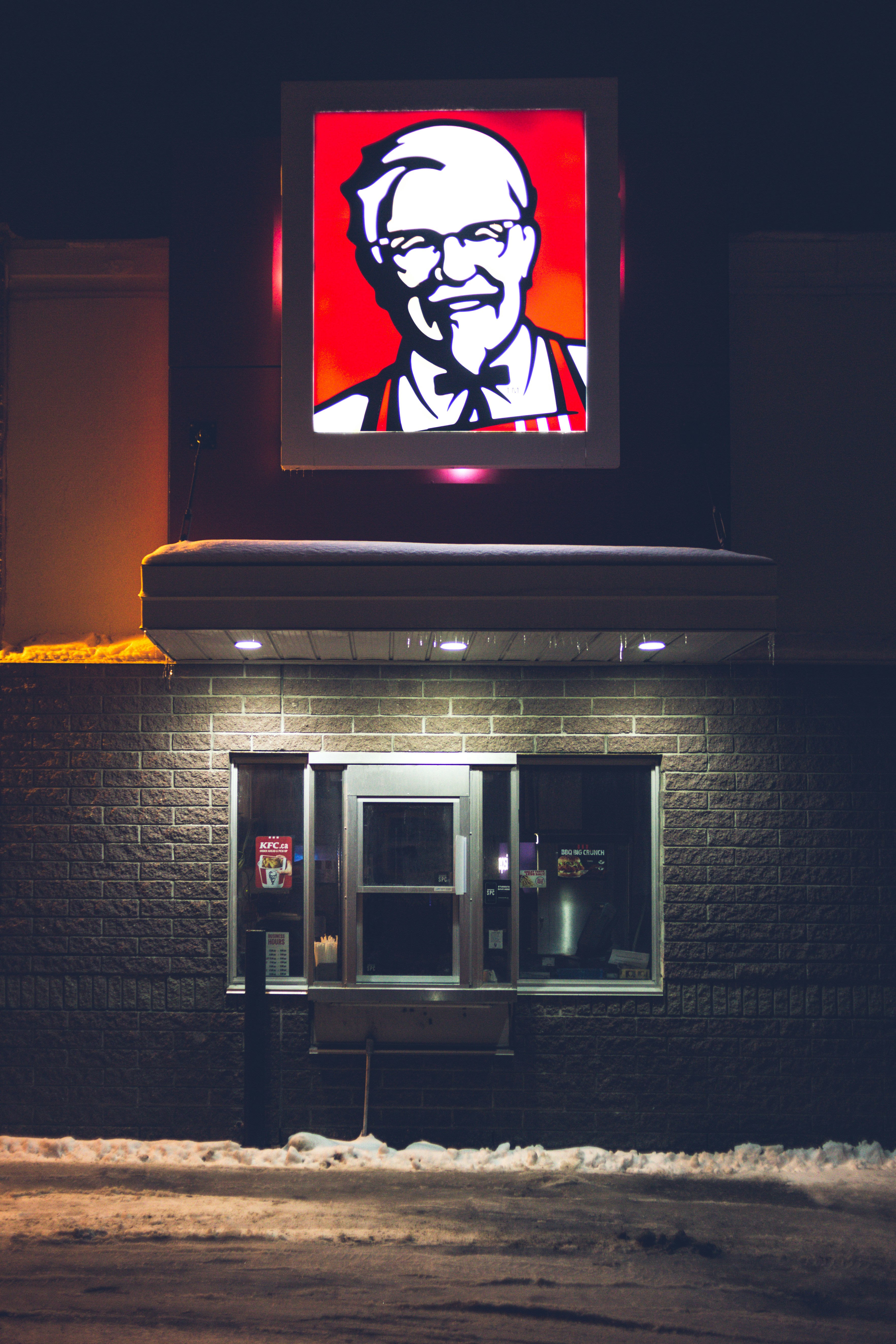 Crimson Colonel at Night: Snow-Touched KFC Facade