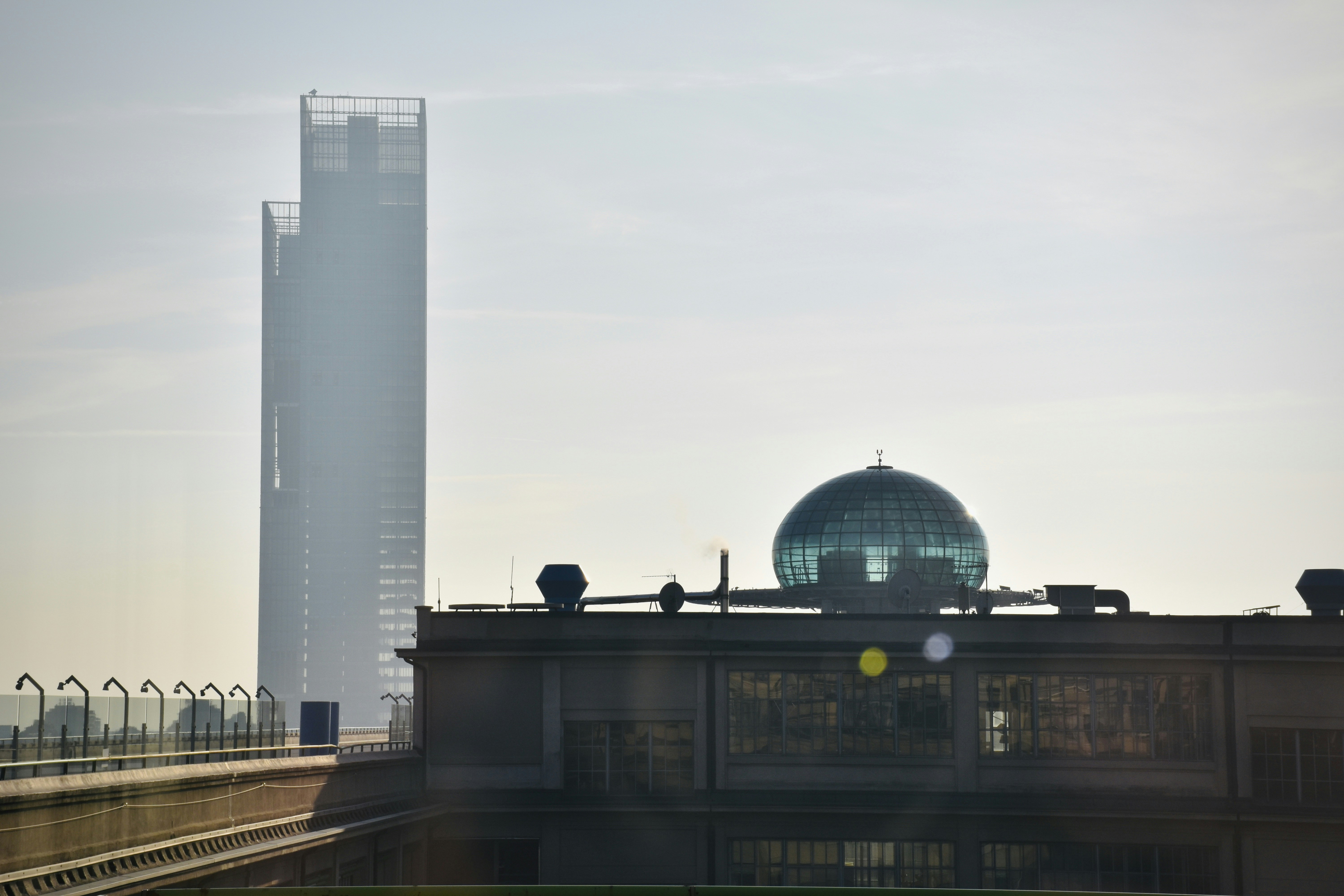 The bolla (bubble) on top of the historic Fiat car factory in Lingotto, Torino, Italy. In the background the building of the regional administration of Piemonte by M. Fuksas. | photography of brown building during daytime