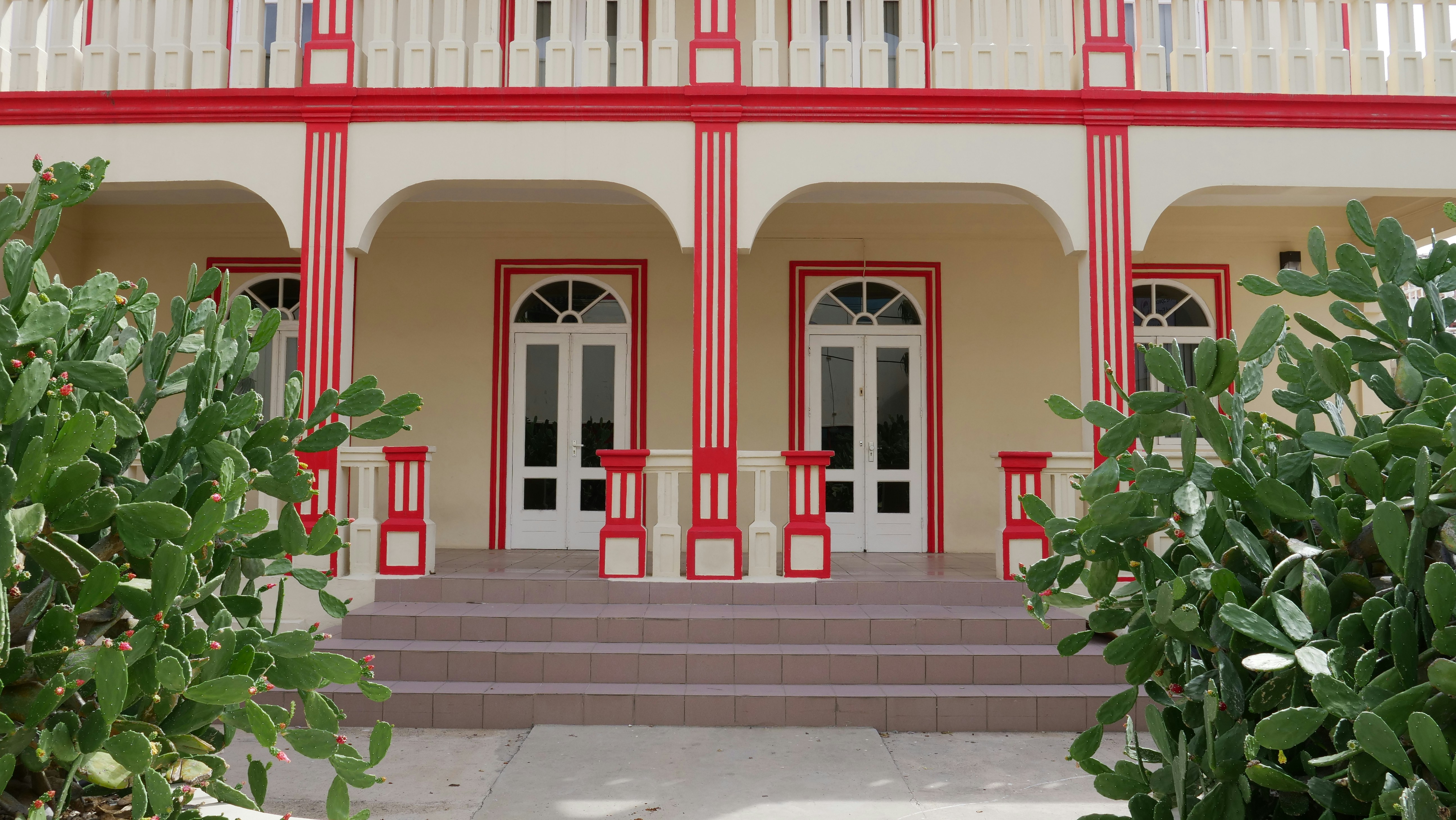 Crimson Frames and Cream Veranda: A Symmetrical Entrance