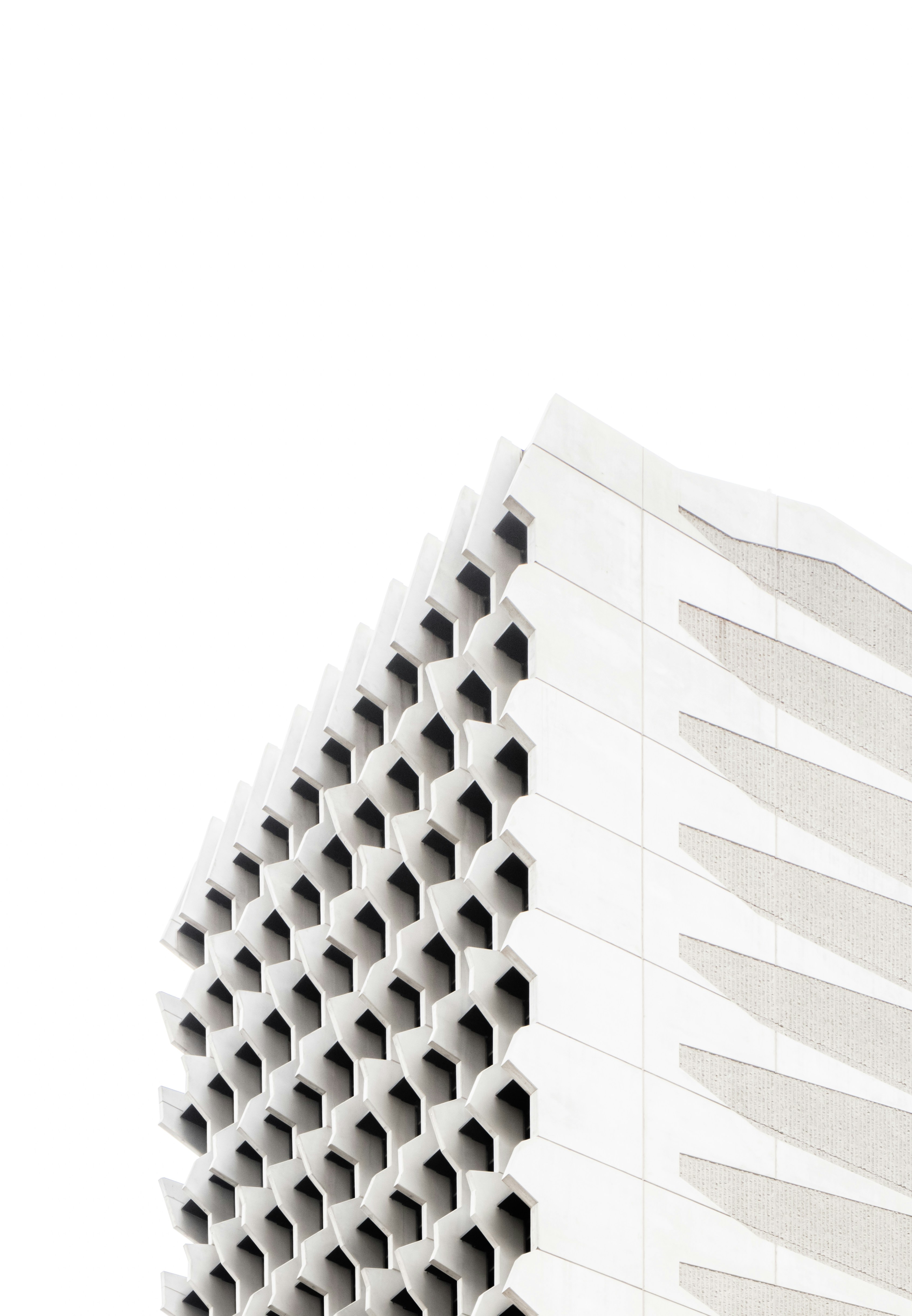 Diagonal Hex Grid: Repeating Voids on a White Facade