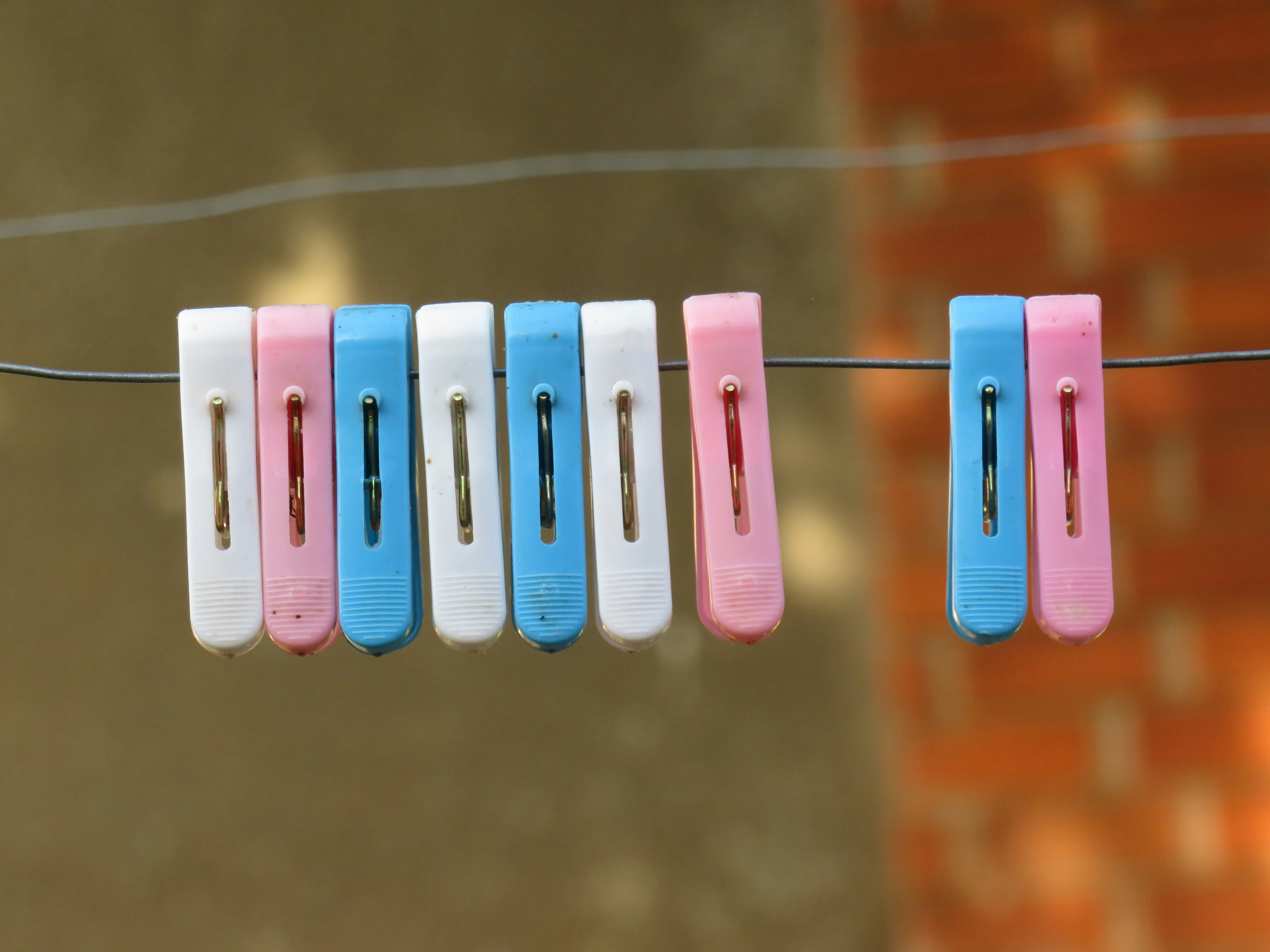 Colorful clothespins arranged on a wire against a blurred background, showcasing simple yet vibrant design elements.