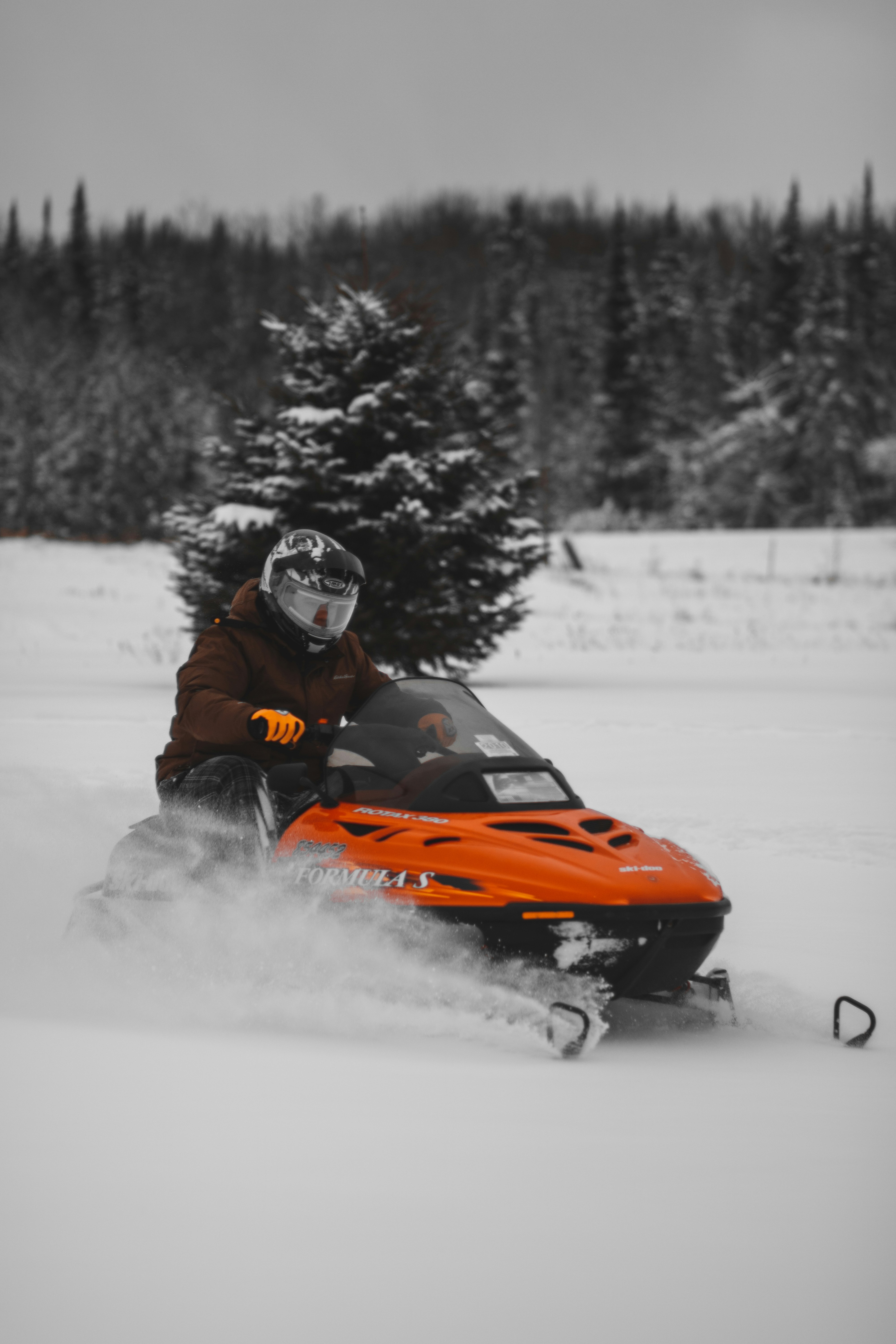 Blaze on the Snow: An Orange Snowmobile Conquers Winter's Quiet