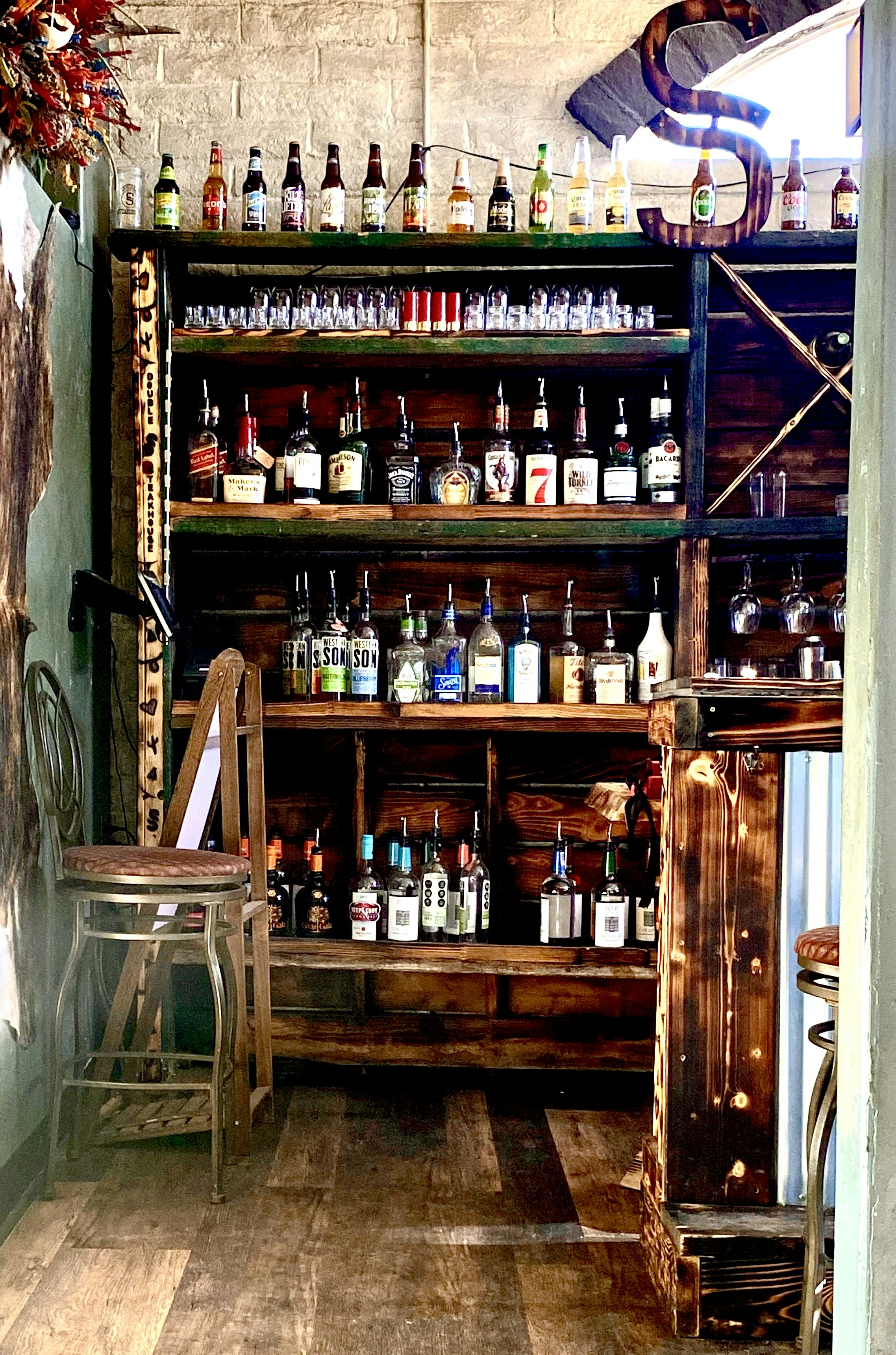 Shelf of Spirits: a rustic bar backdrop stacked with bottles